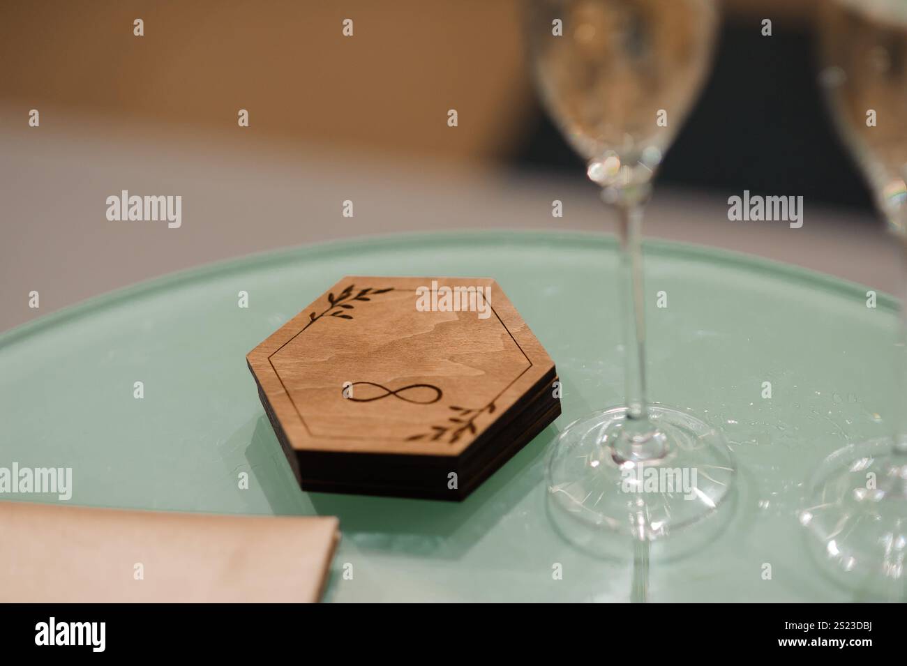 Elegant Wooden Coaster with Infinity Symbol on Glass Table Stock Photo ...