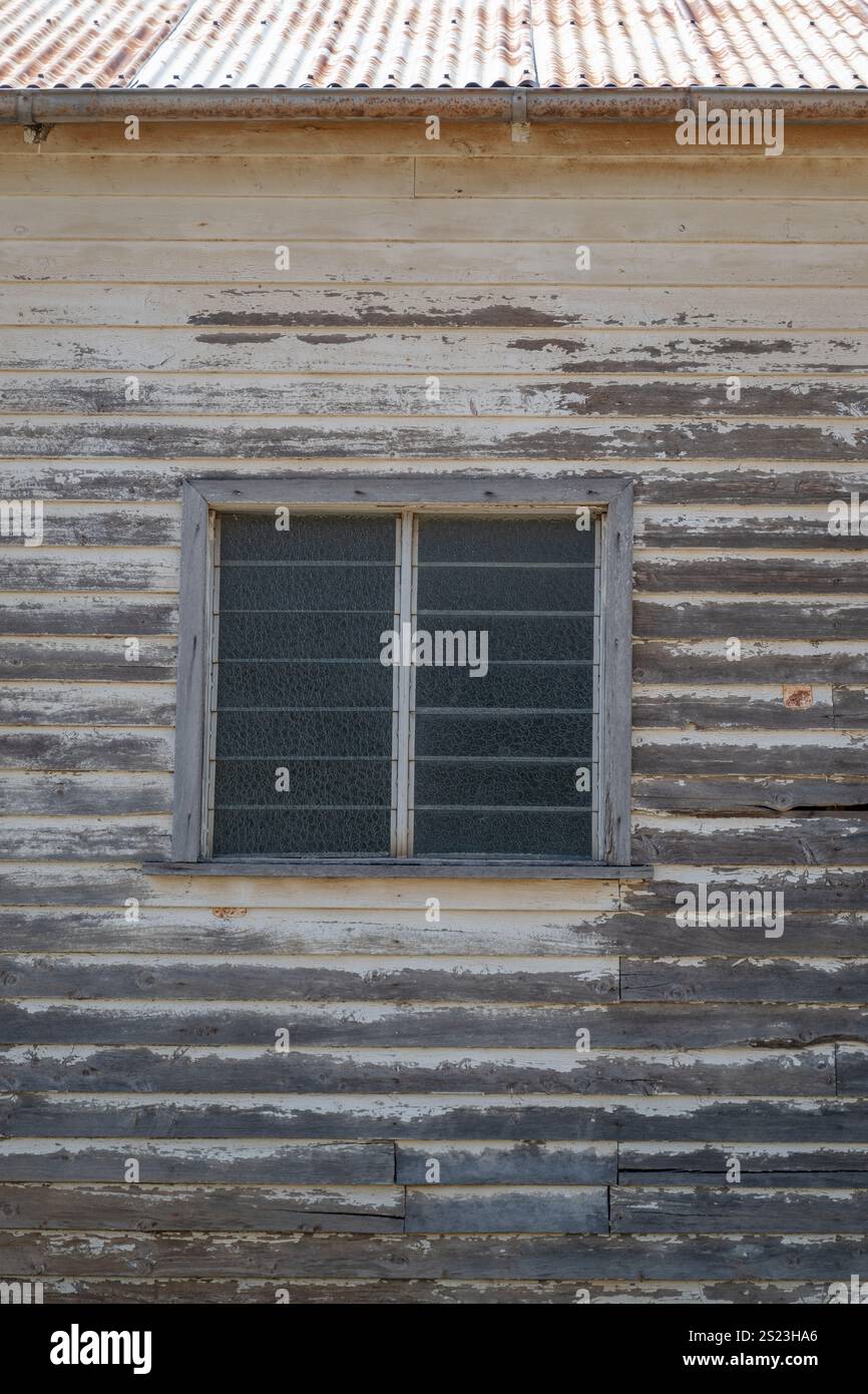 Old abandoned timber house and window, faded peeling paint, derelict ...