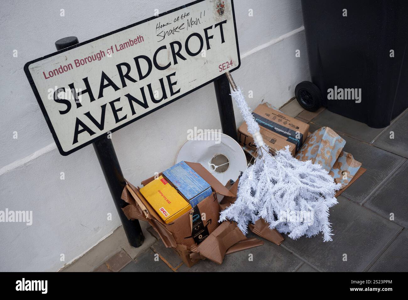 A dumped white Christmas tree and present packaging including Amazon ...