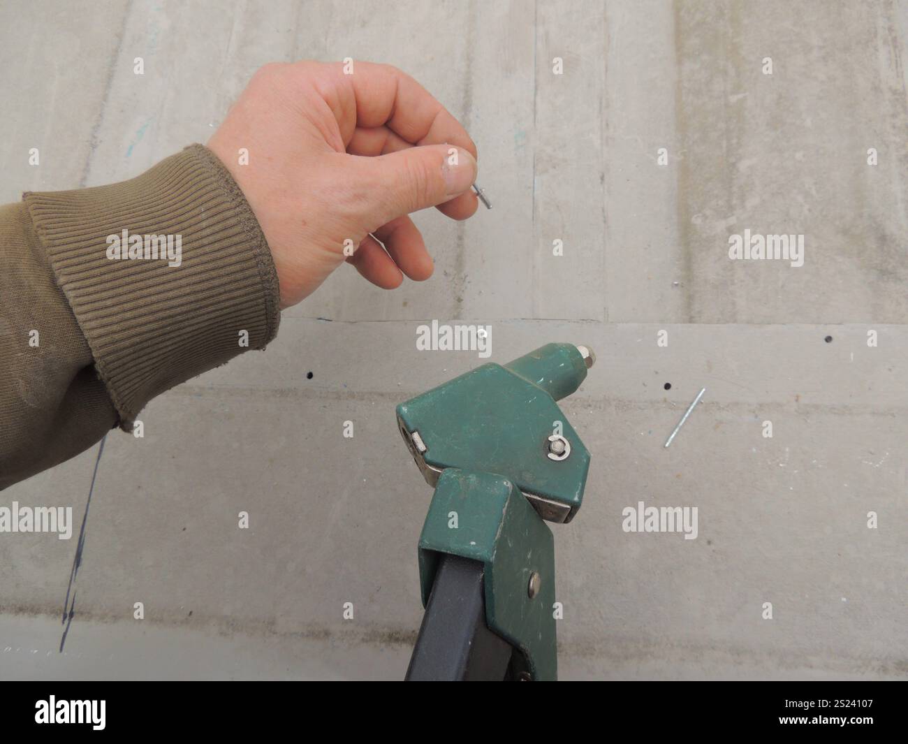 Hand with metal rivet and tool for fixing iron sheets, upper part of ...