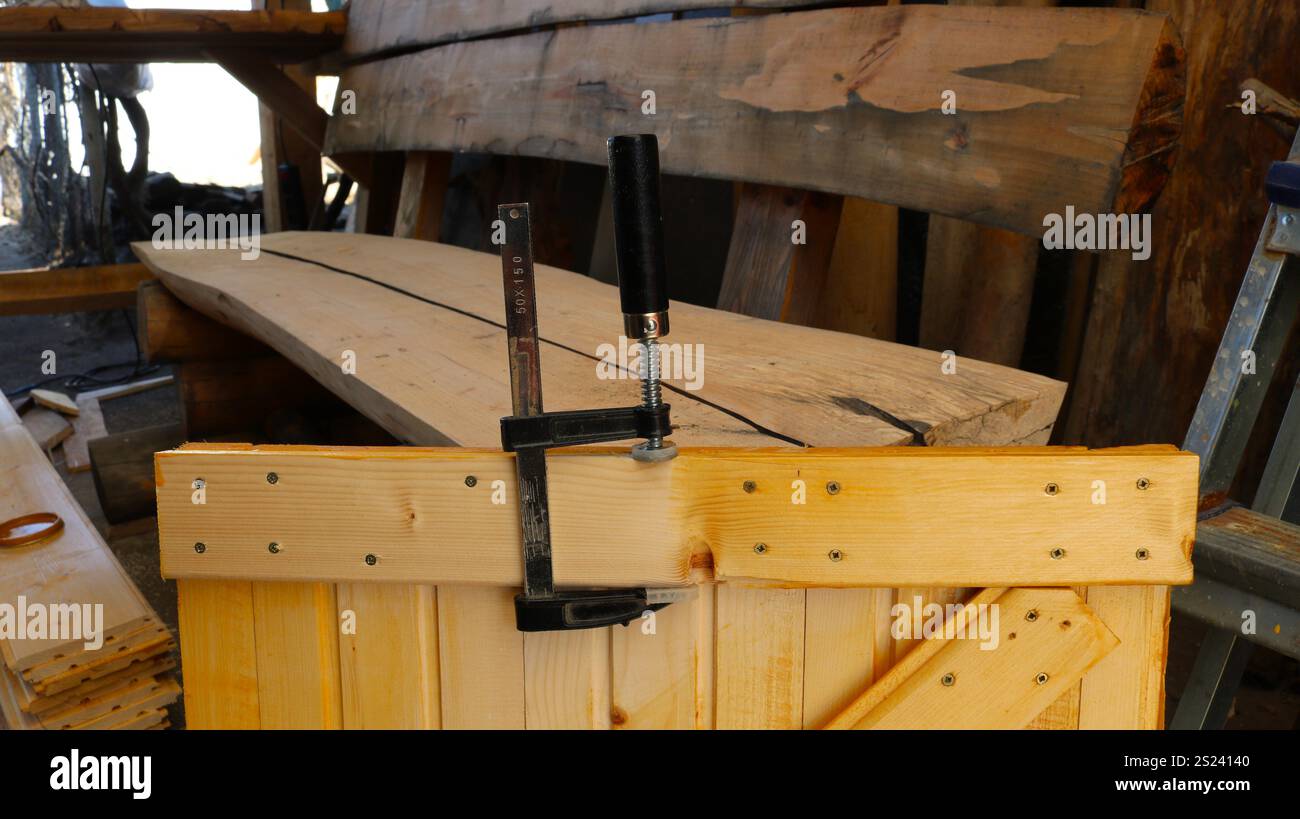 using a clamp to glue a chip to a chip in a wooden barn door in a ...