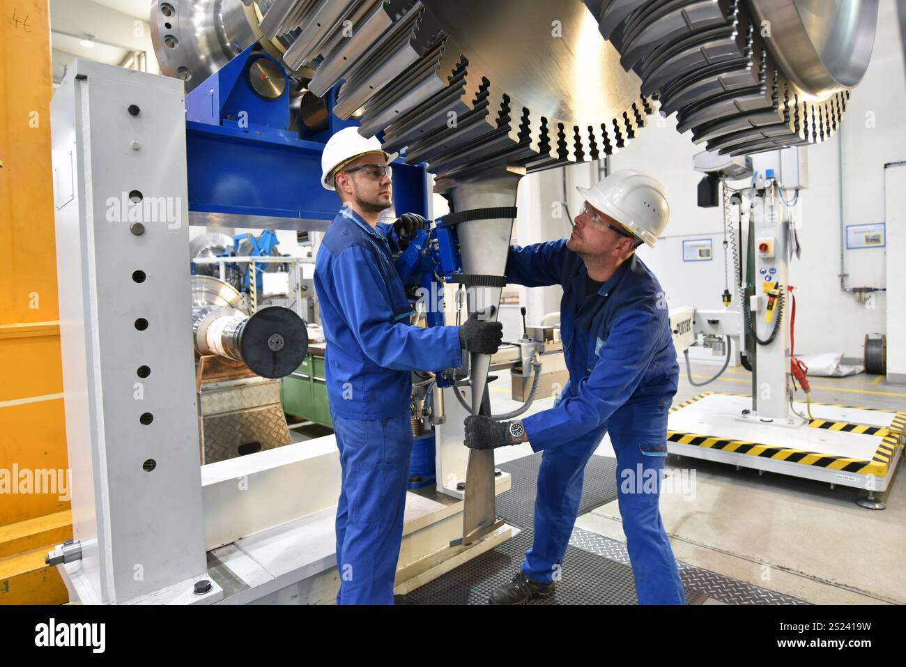 workers assembling and constructing gas turbines in a modern industrial ...