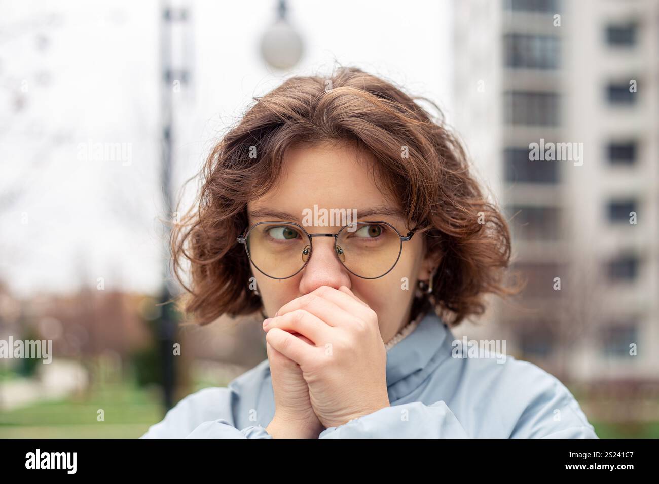 Freezing woman. A young beautiful frozen girl suffers from cold weather ...