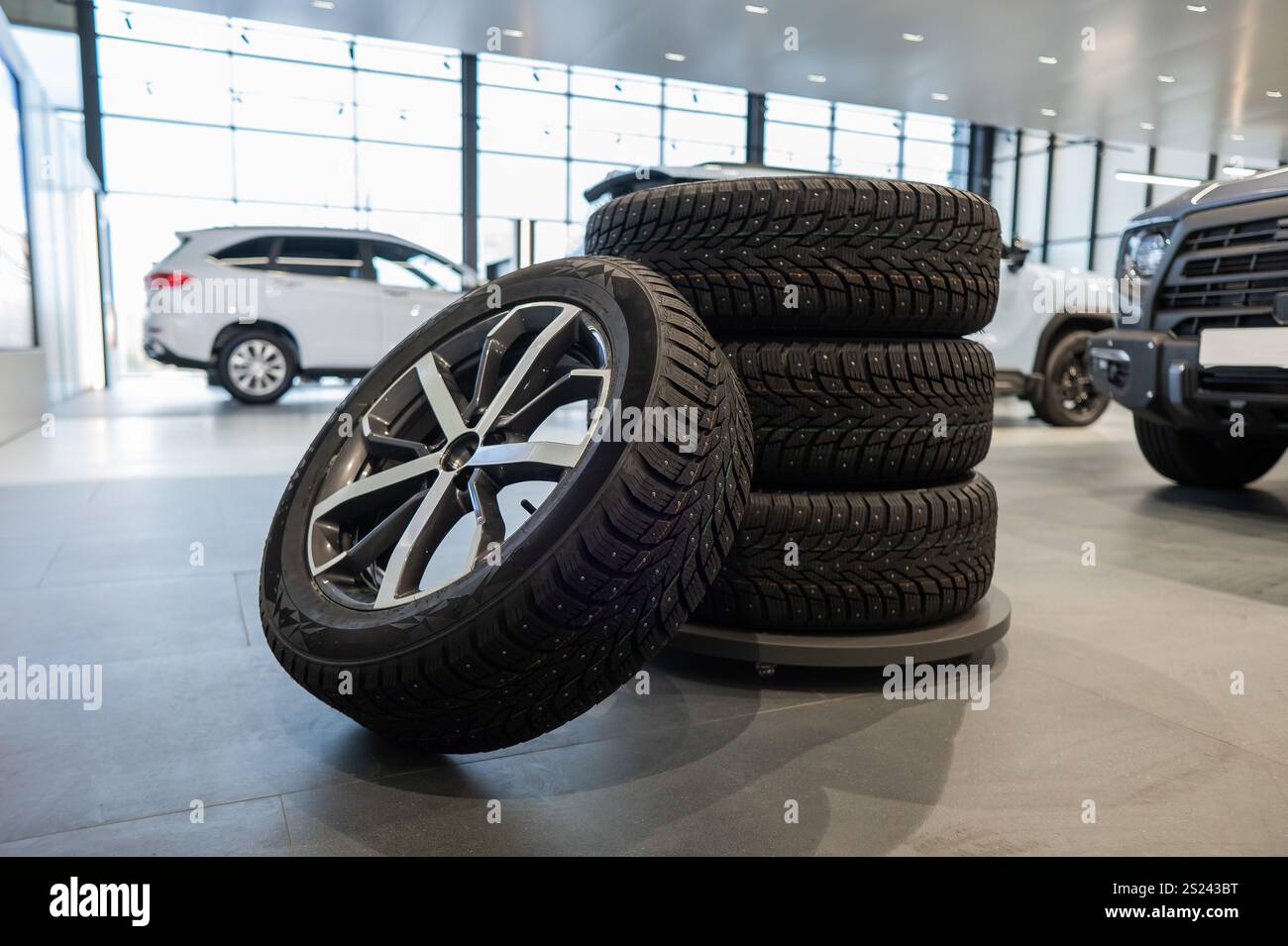 New wheels with studded tires against the background of new cars Stock ...