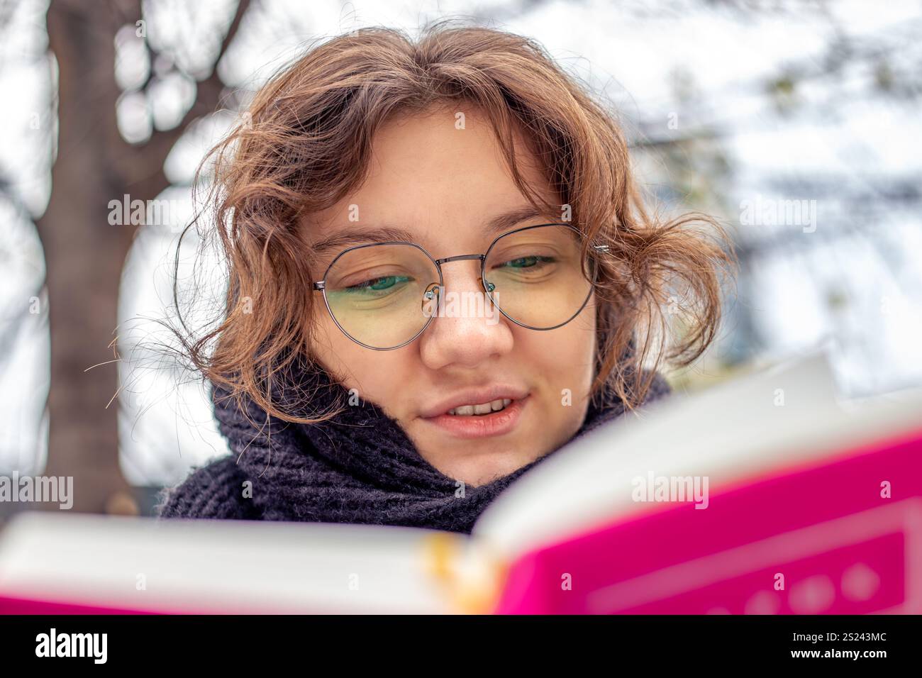 Girl reading a book on the street close-up. Teenage girl reading a book ...