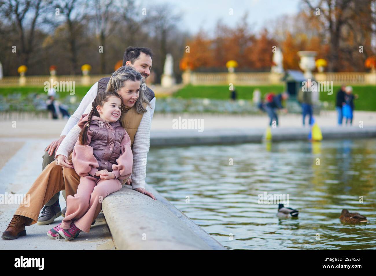 Happy family of three, father, mother and daughter enjoying family time ...