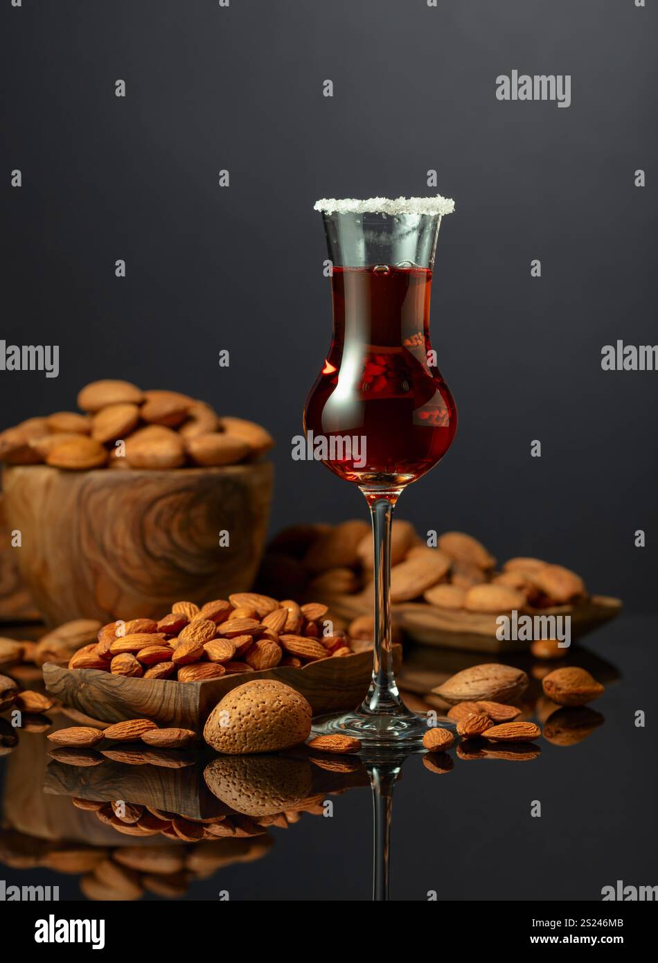 Strong alcoholic Italian liqueur Amaretto with almonds nuts on a black ...