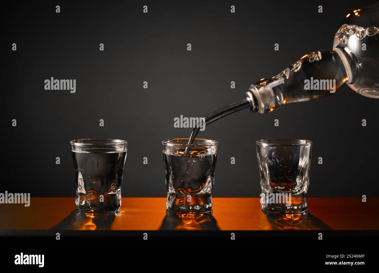 Alcoholic shots of vodka or strong drink in small glasses. Barman ...