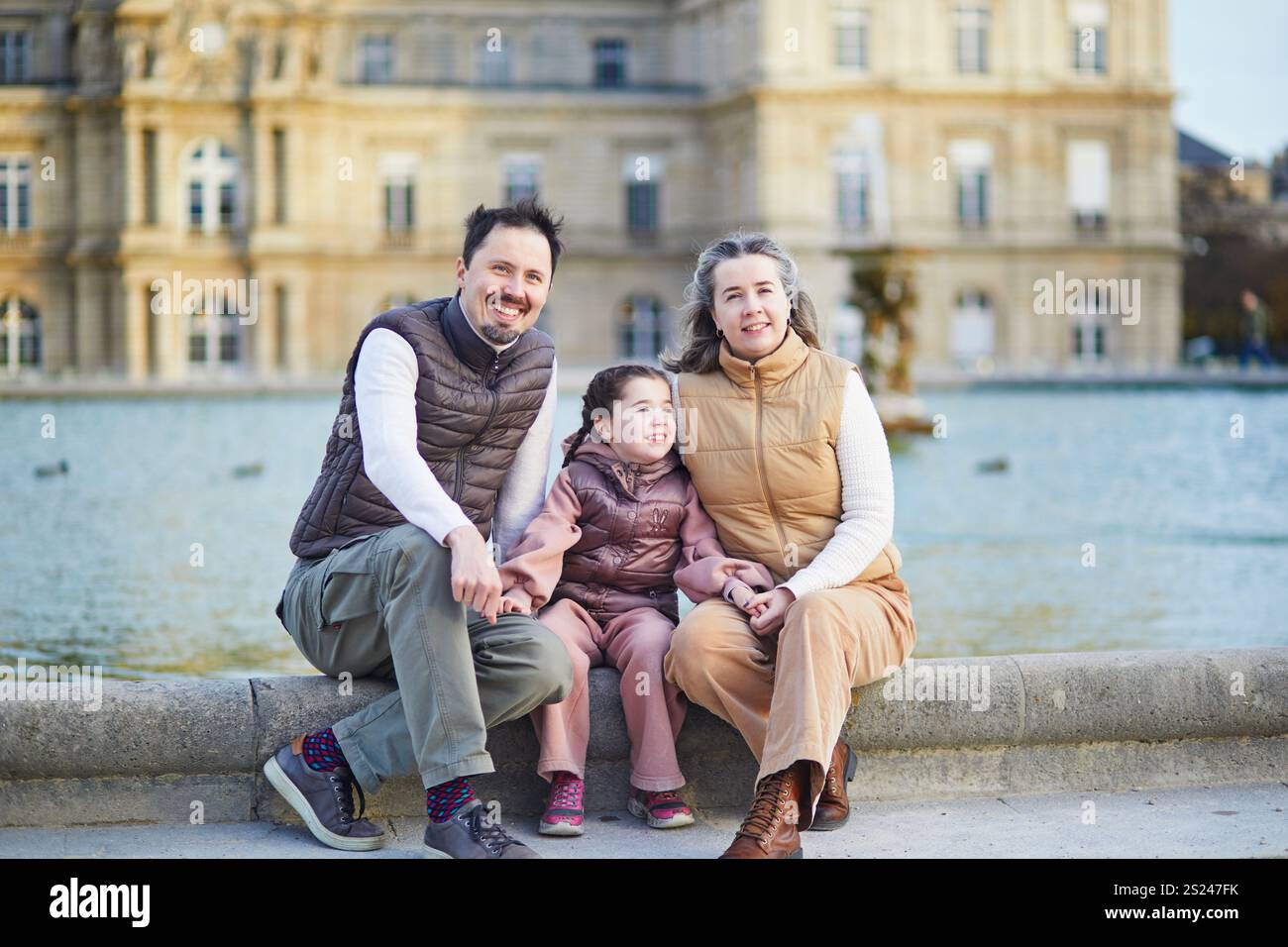 Happy family of three, father, mother and daughter enjoying family time ...