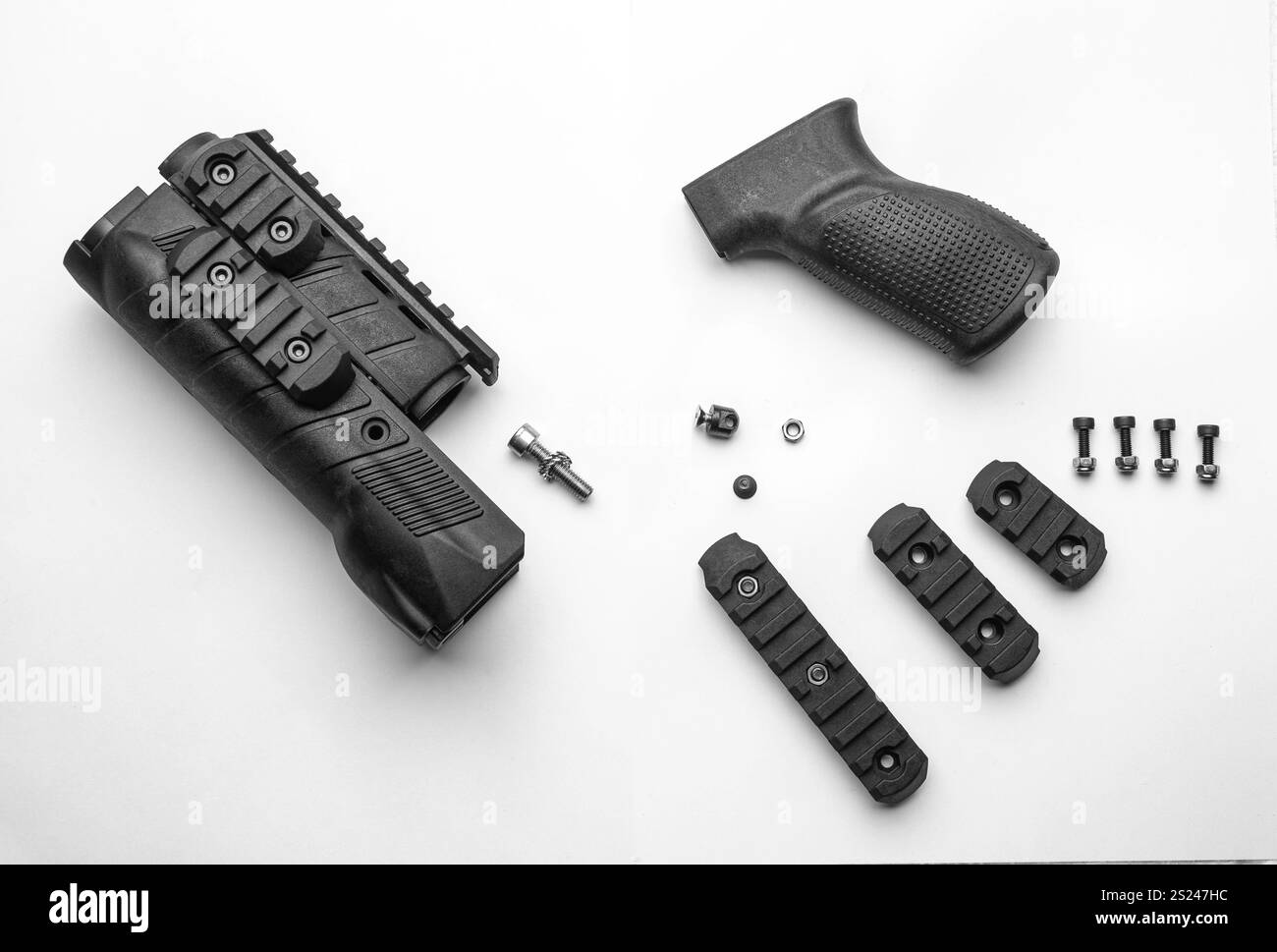 Parts of a firearm accessory, including a handguard, grip, screws, and ...