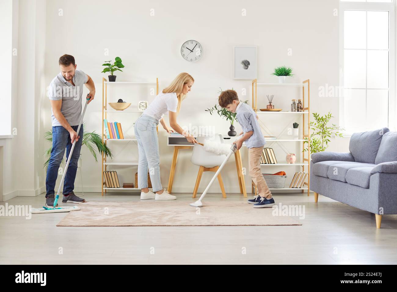 Young family with child boy cleaning house and wiping dust together in ...