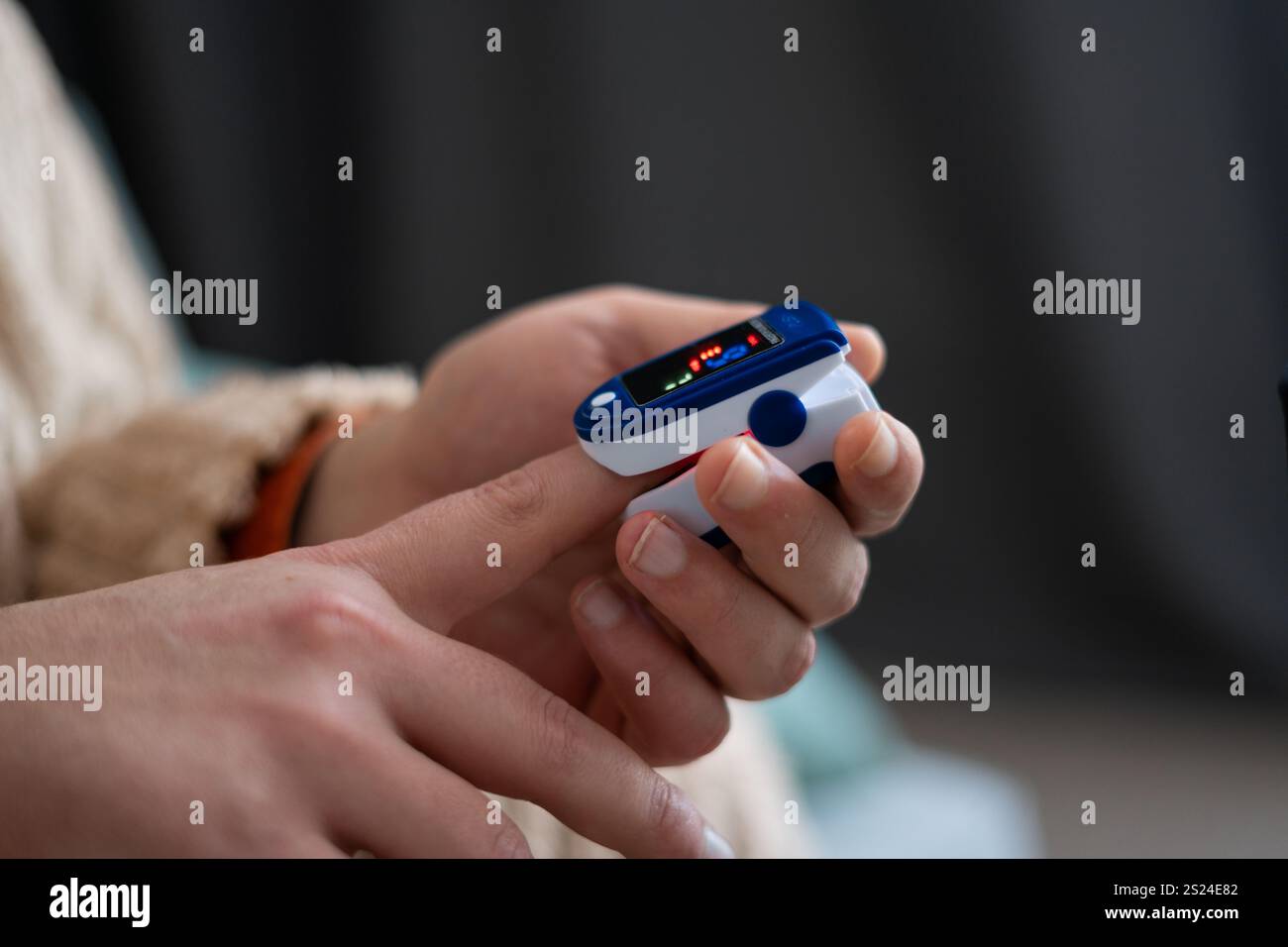 Pulse oximeter on male hand measuring oxygen saturation at home ...