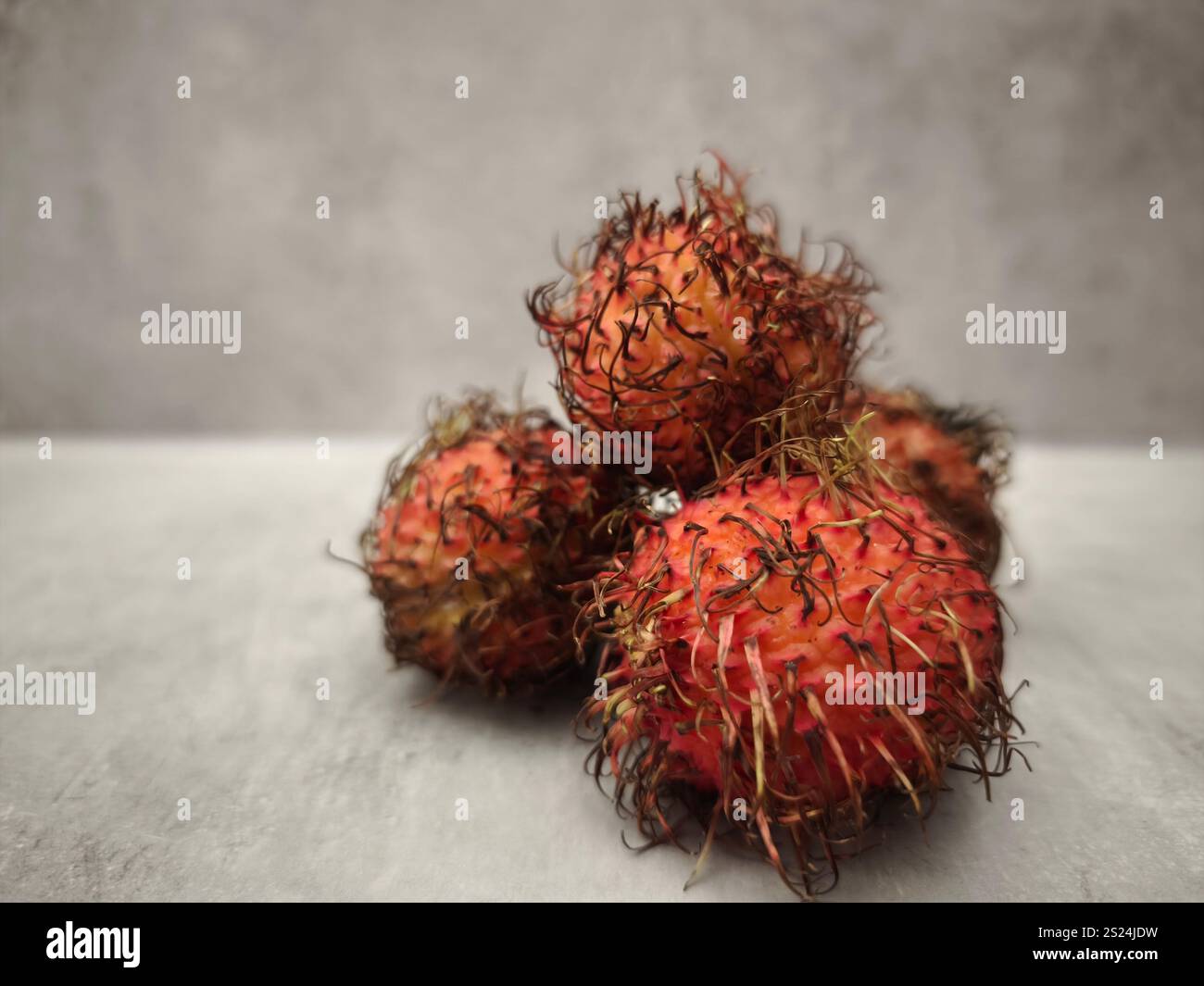 Several ripe rambutan fruits, with their characteristic hairy exterior ...