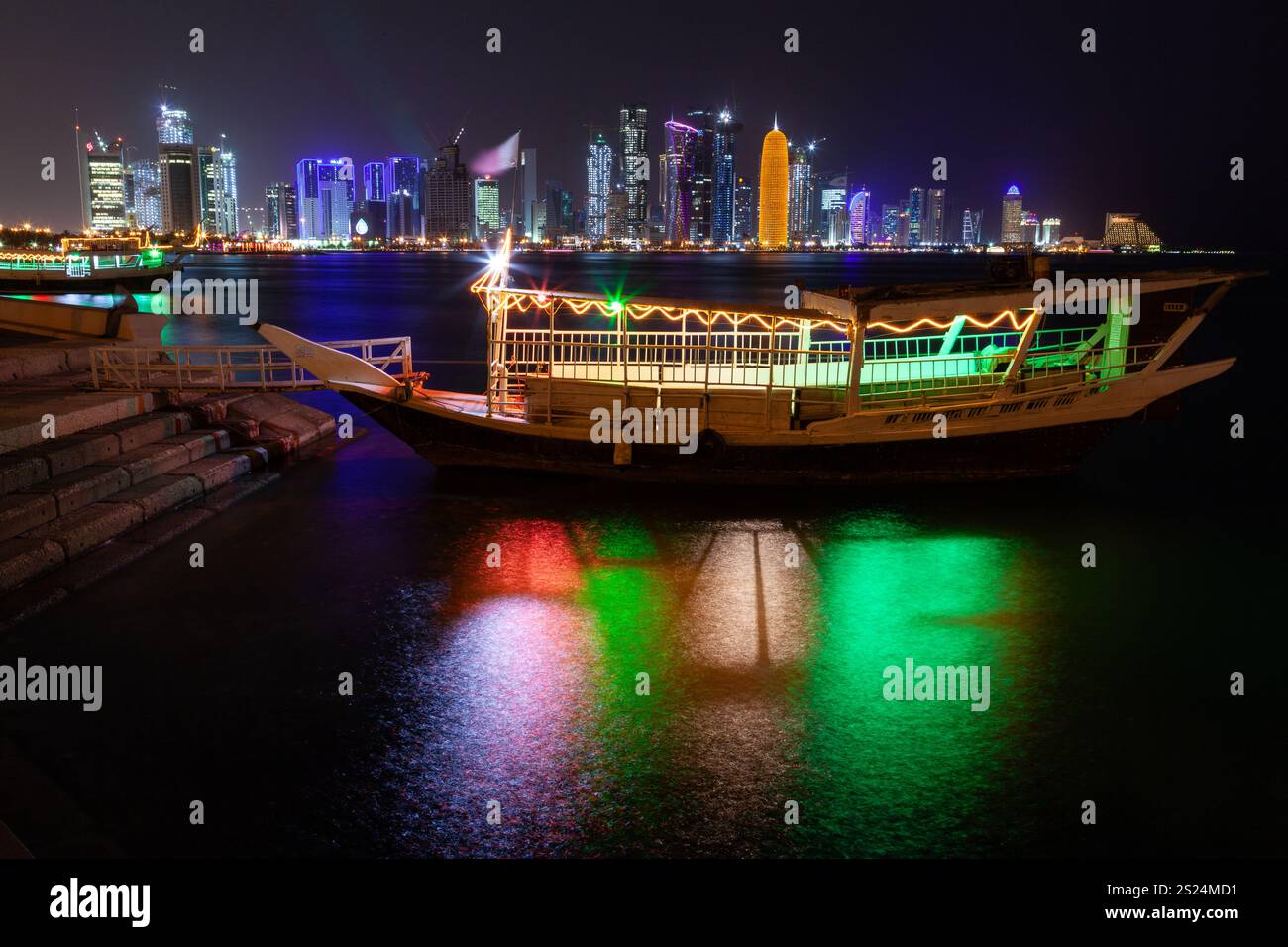 Night Doha city view, Arabic traditional cruise dhow boat docked at the ...