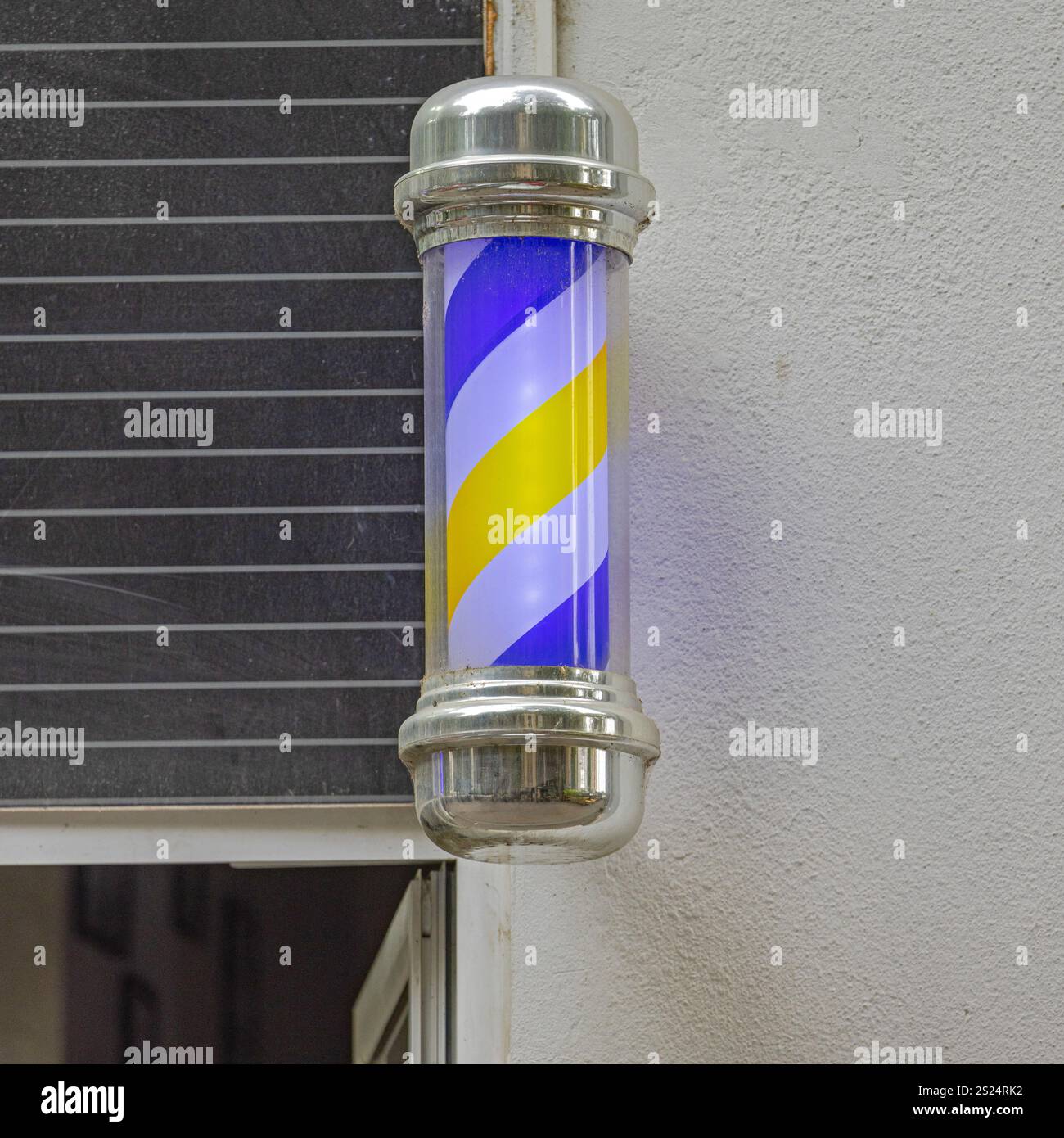 Rotating Spiral Lamp in Front of Barber Shop Pole Sign Stock Photo - Alamy