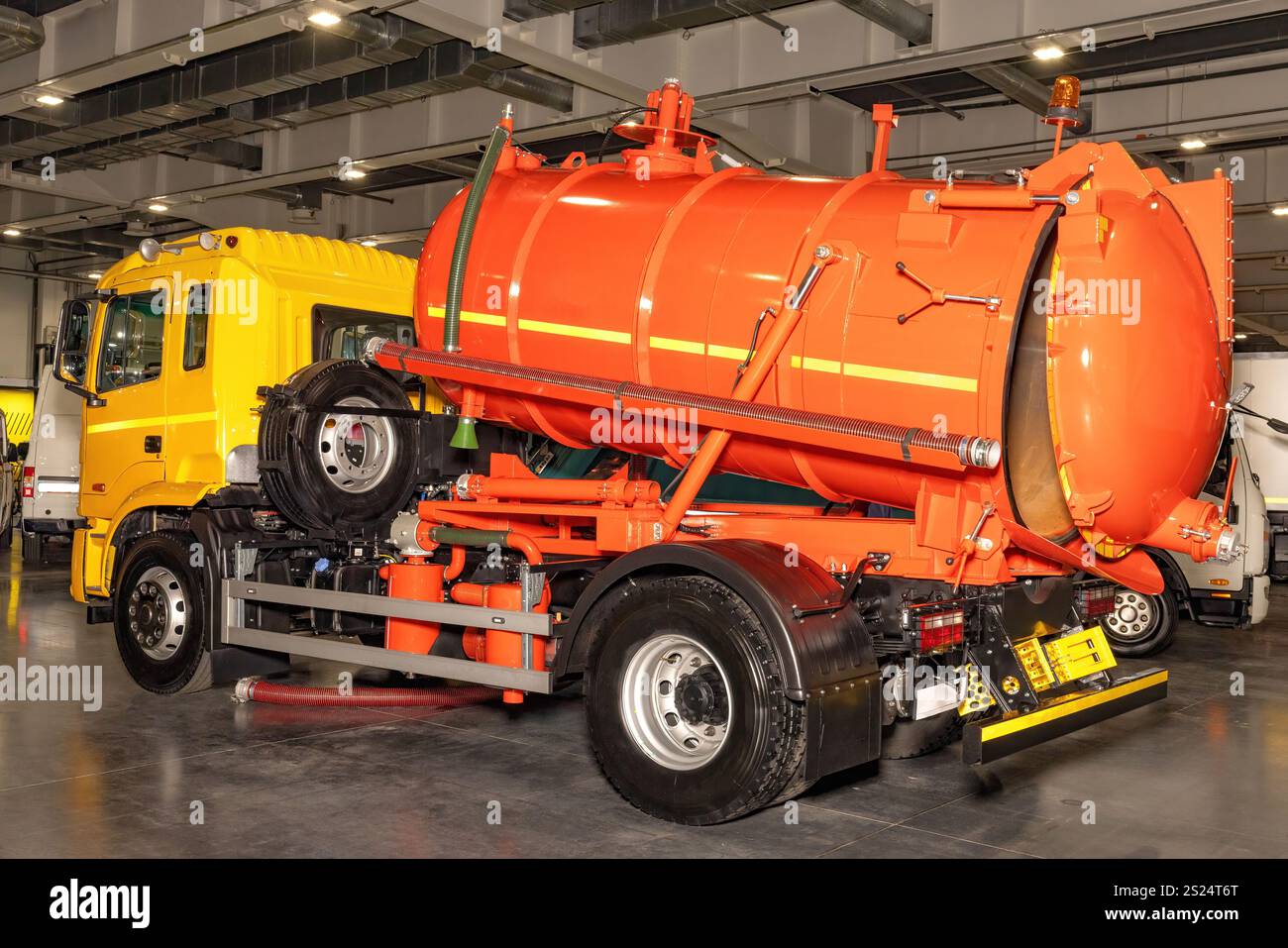 Bright orange industrial truck poses in a modern warehouse during a ...