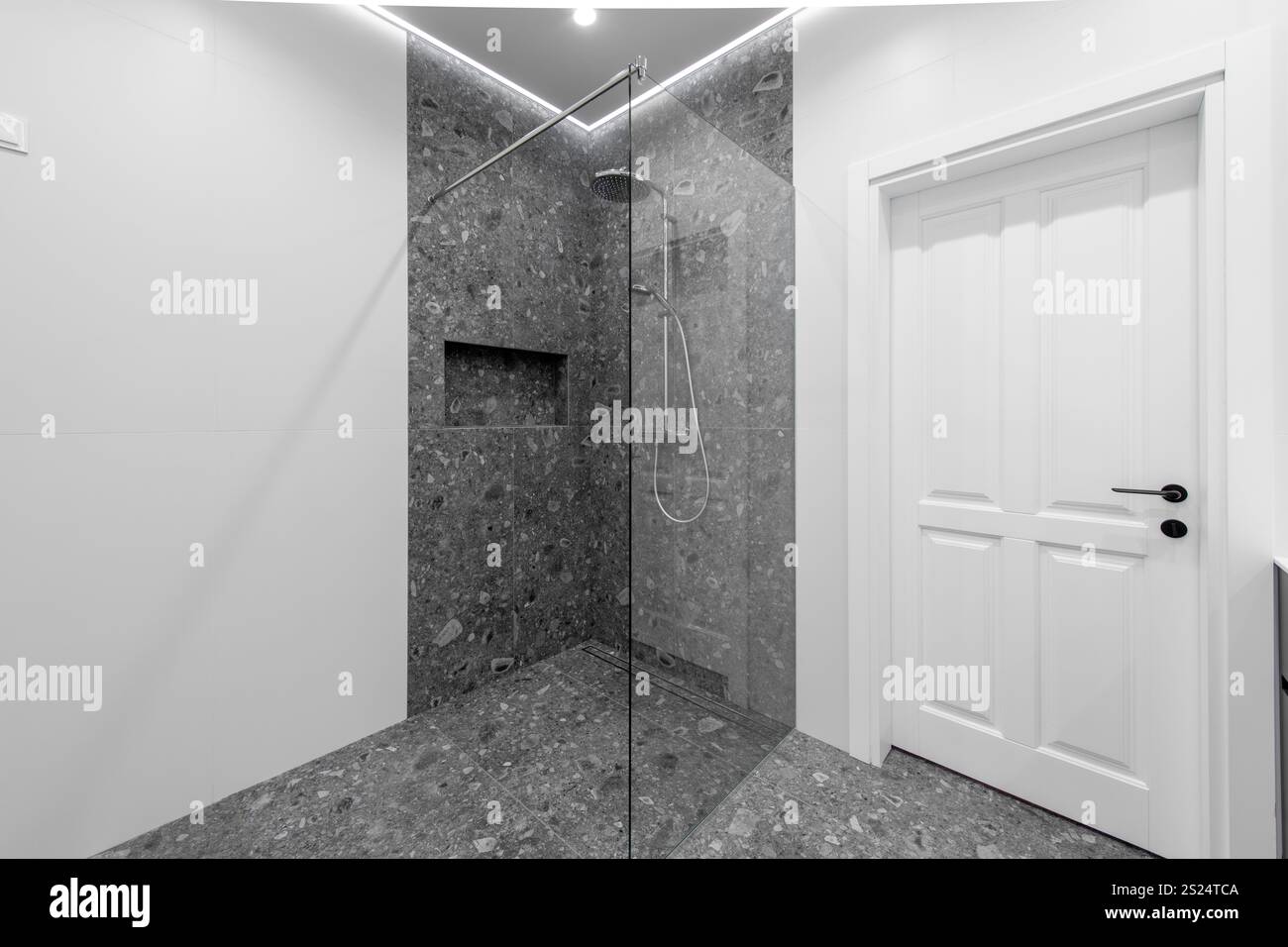 Contemporary bathroom design featuring sleek grey tiles, a glass shower ...