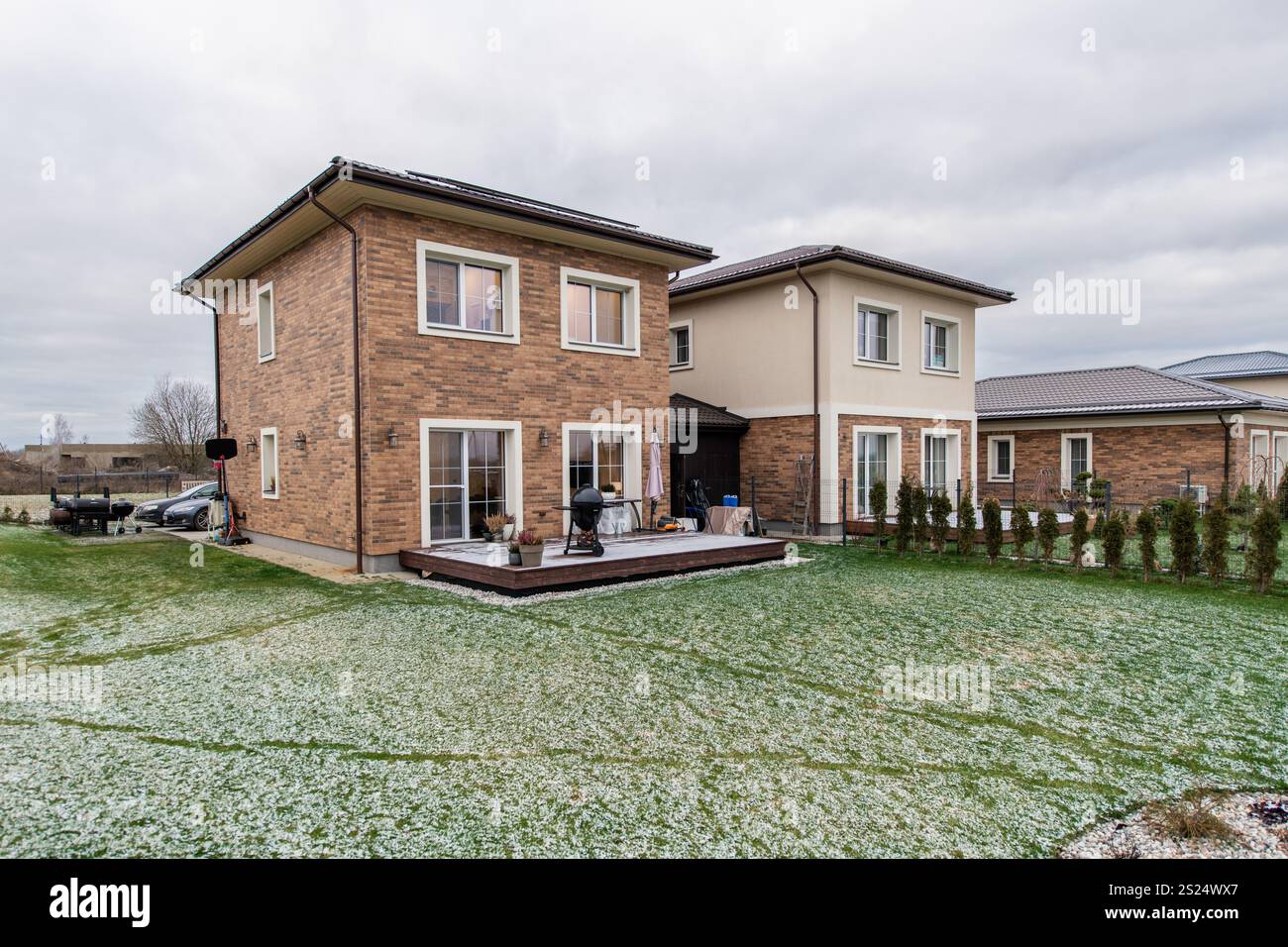 A brick house with a patio and a driveway. The house is surrounded by a ...