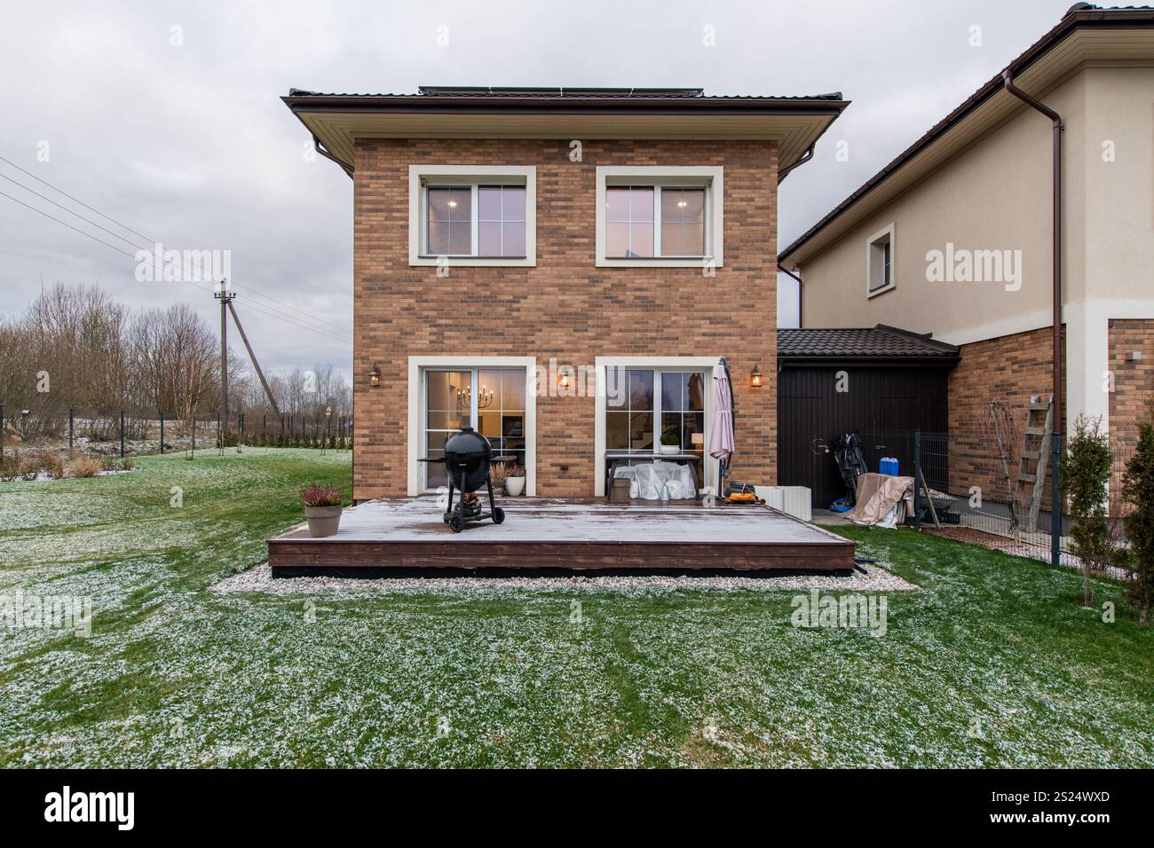 A brick house with a patio and a driveway. The house is surrounded by a ...