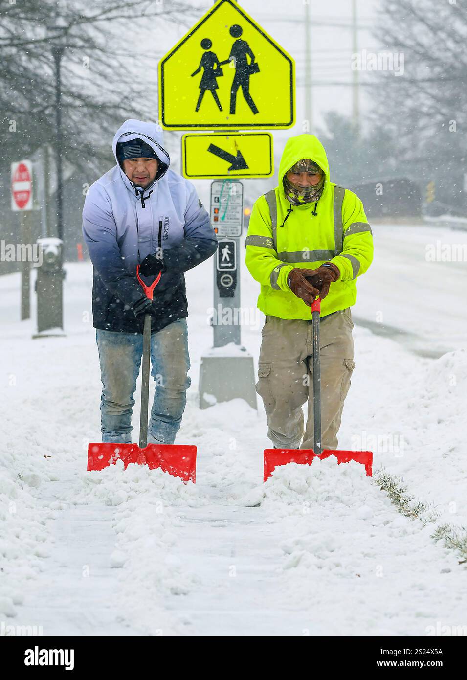 Emanuel Lopez, left, and Roberto Gomez team up to shovel snow off a ...