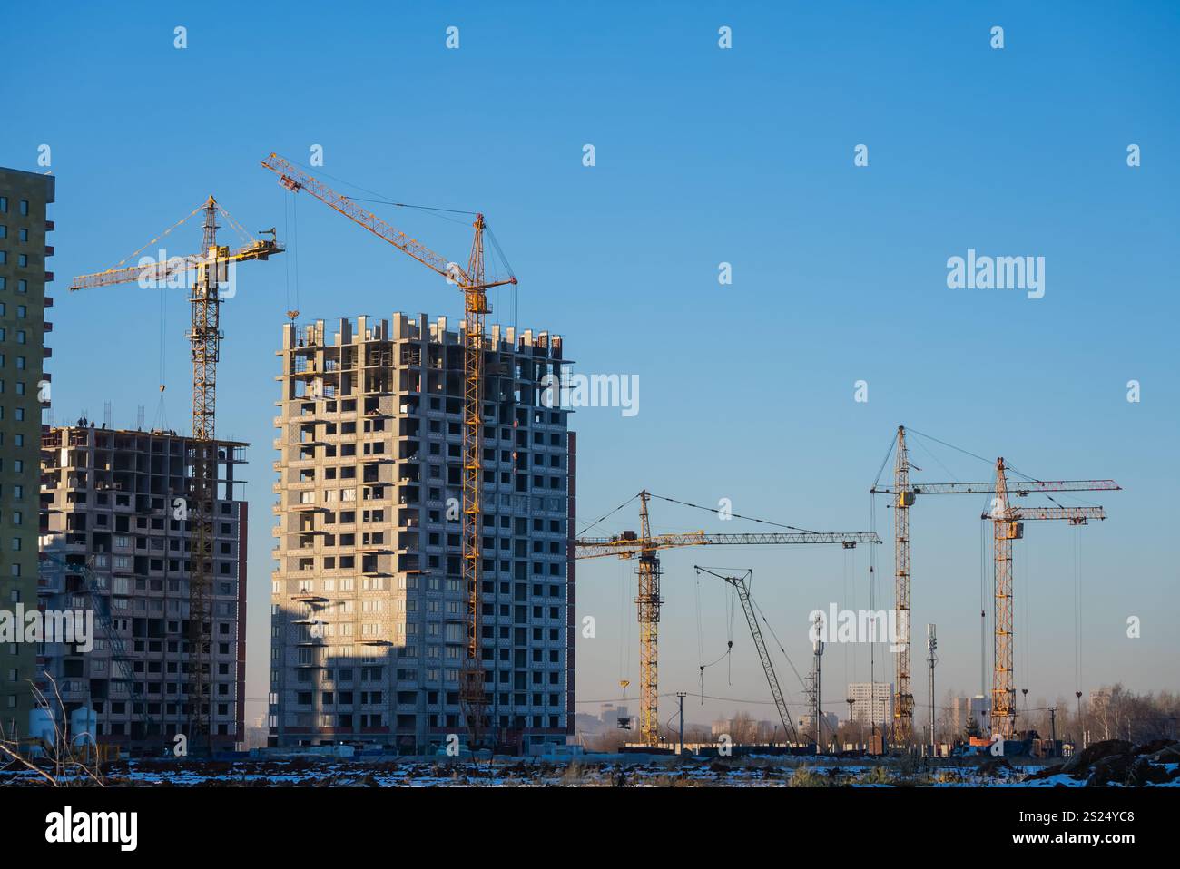 Multiple construction cranes working on modern residential buildings ...