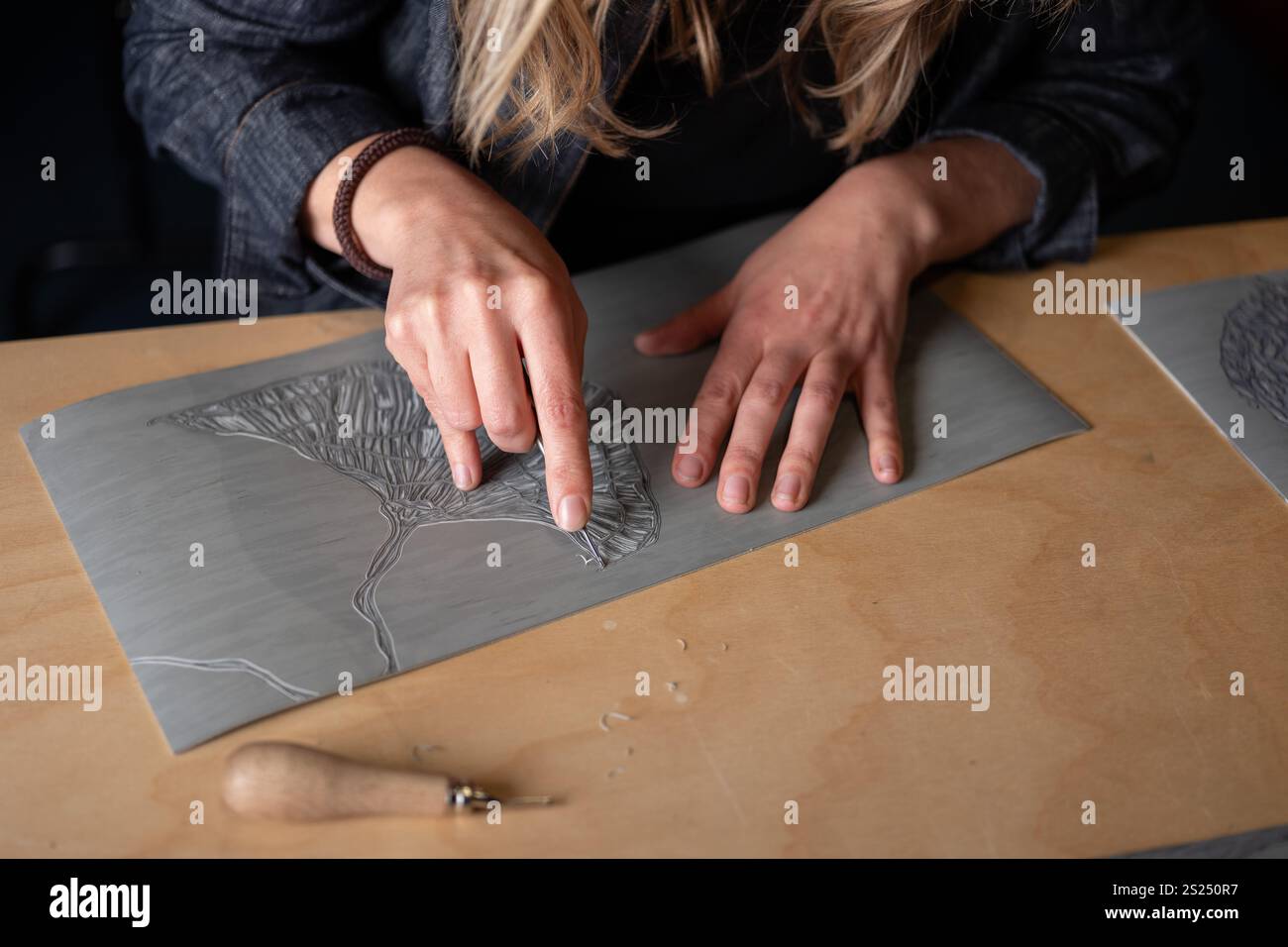 An artist carving a woodcut design for printing Stock Photo - Alamy