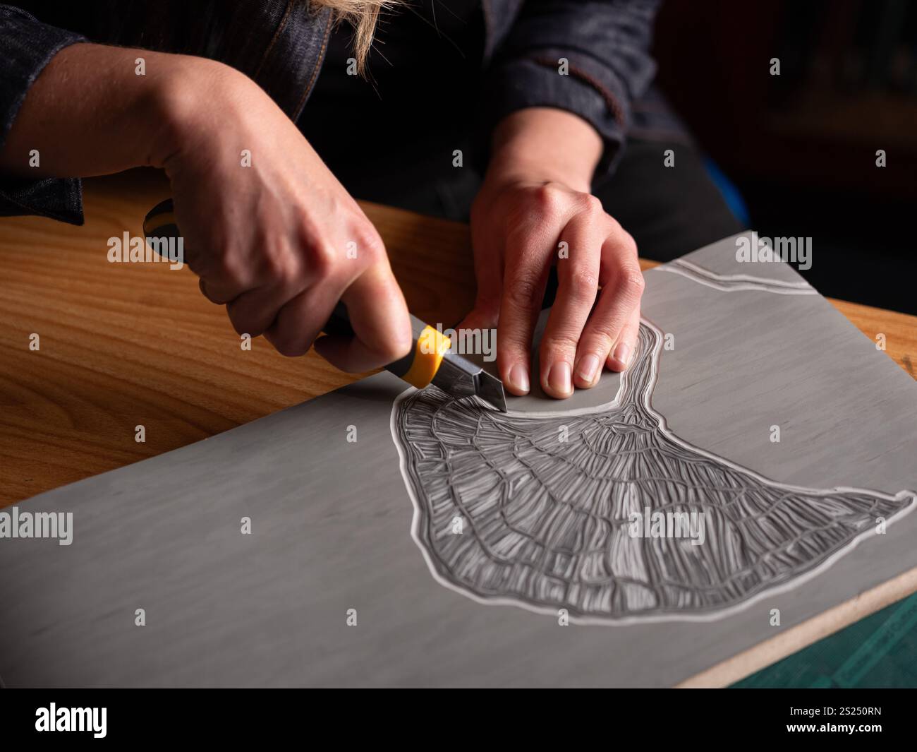 An artist carving a woodcut design for printing Stock Photo - Alamy