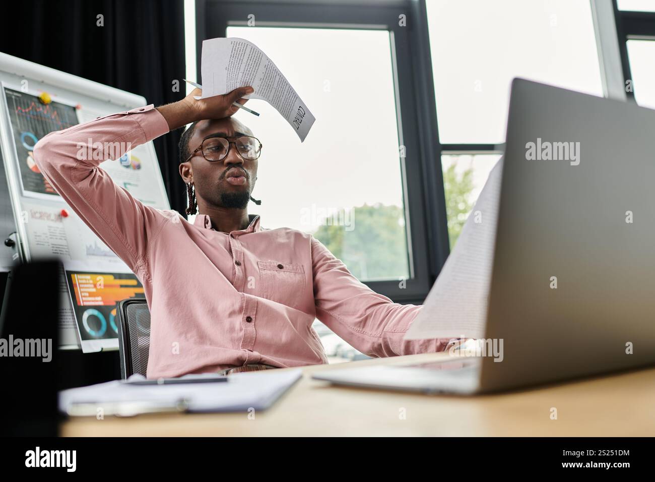 Young African American digital nomad multitasks at a modern workspace ...