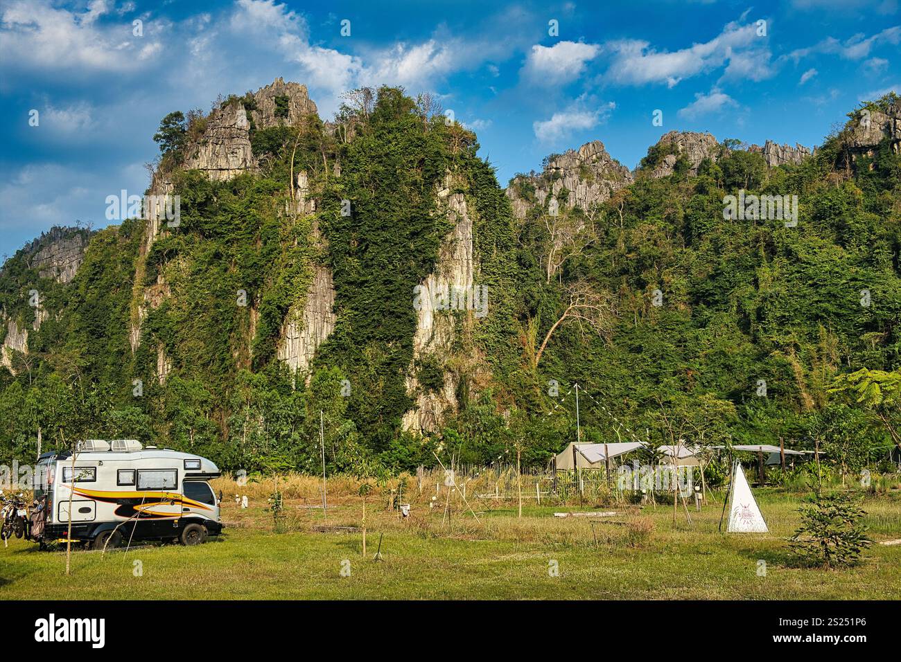 Camping ground with mobile home at the foot of forested limestone rocks ...