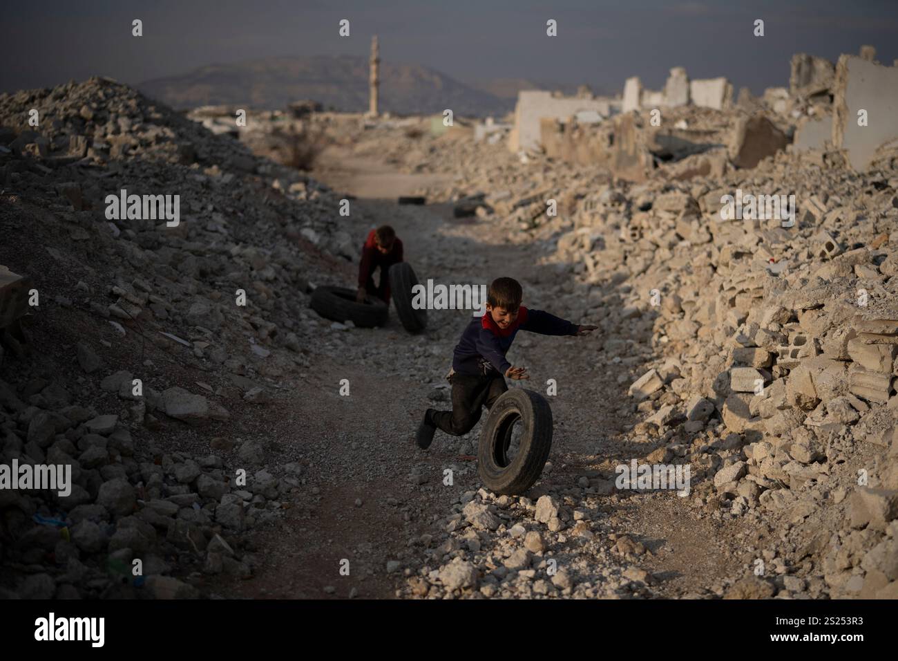 Kids play surrounded by rubble on a an area of houses that were ...