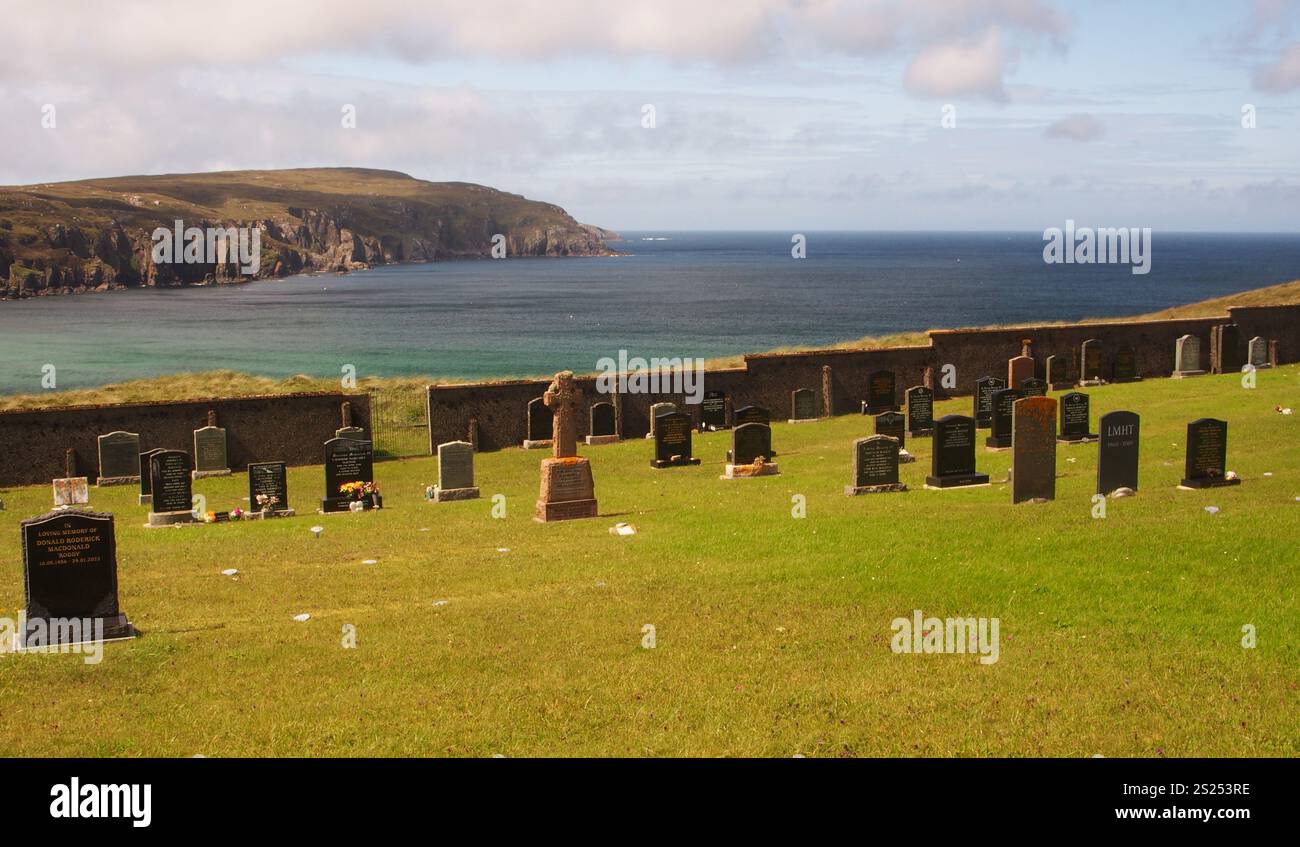 Looking across the cemetery to the beach and far cliffs at Camas na ...