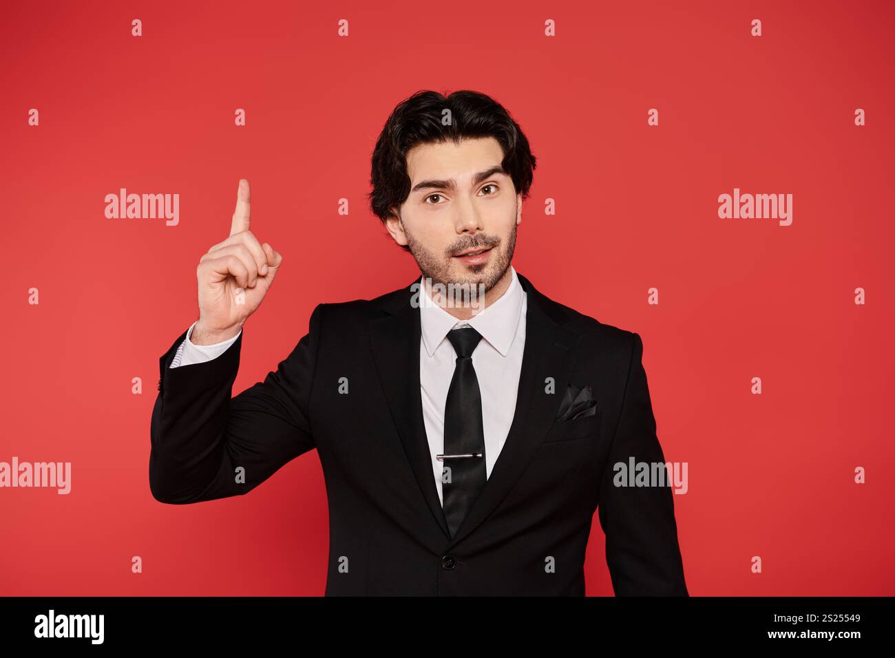 A charismatic young man dressed in a sleek suit stands confidently ...