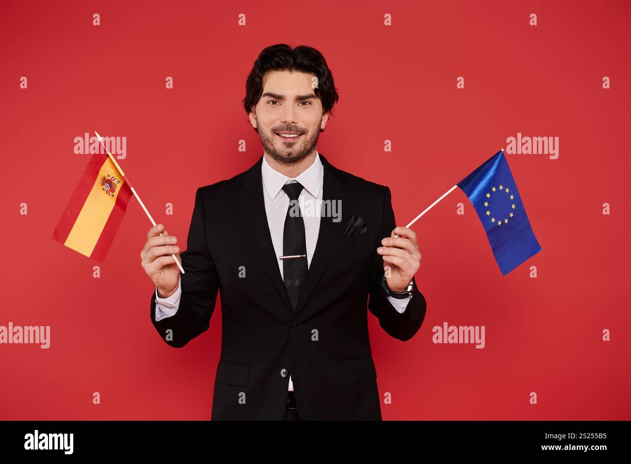 A confident young man in a sleek suit proudly holds the Spanish and EU ...