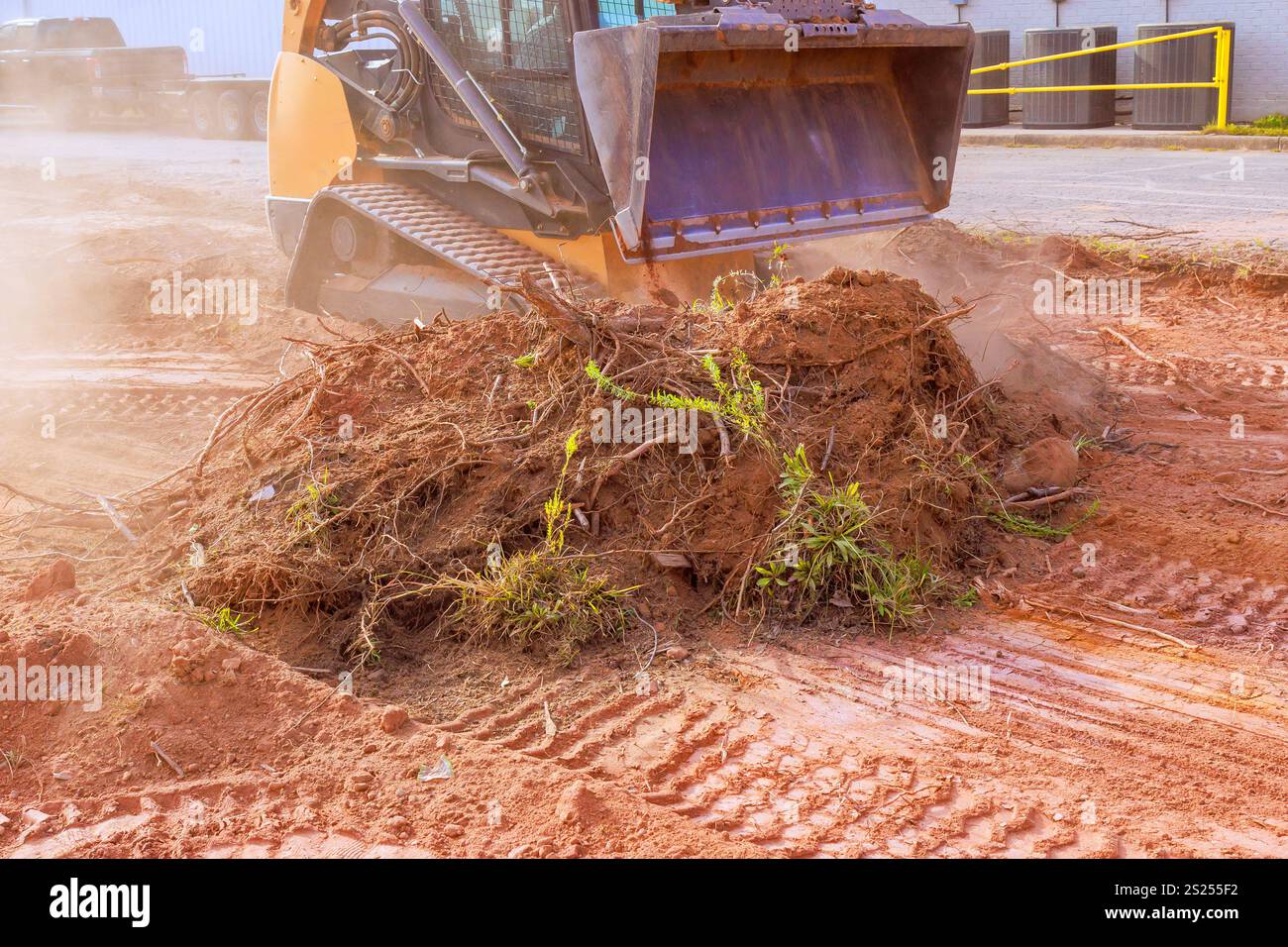 Bulldozer removes soil construction site while dust debris rises in ...