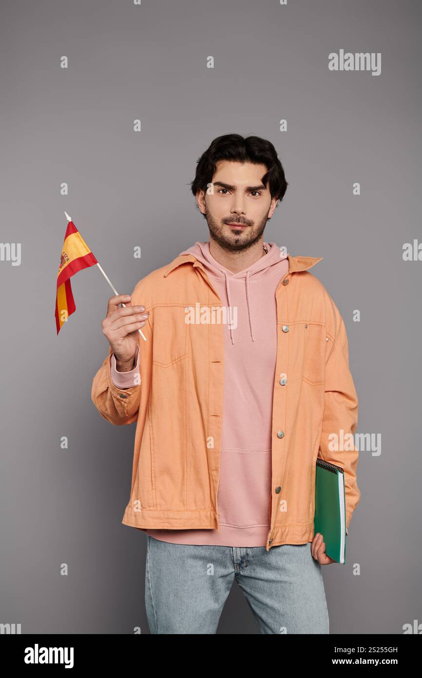 A young man in a stylish outfit proudly holds a small flag, expressing ...