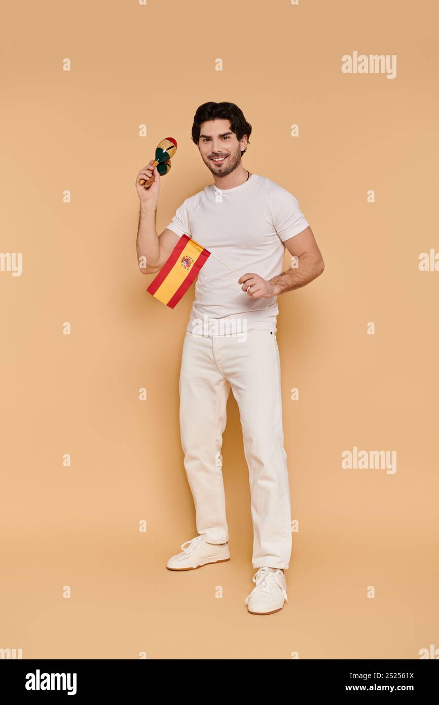 Brunette man happily holding a Spanish flag and sunglasses, creating a ...