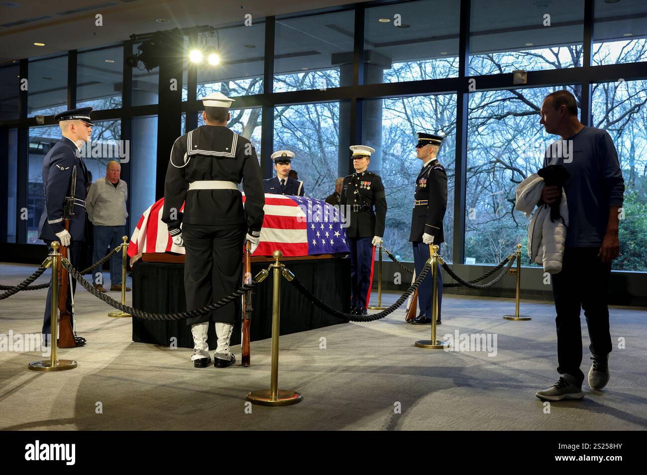 Members of the joint services military honor guard stand by the casket bearing the remains of ...