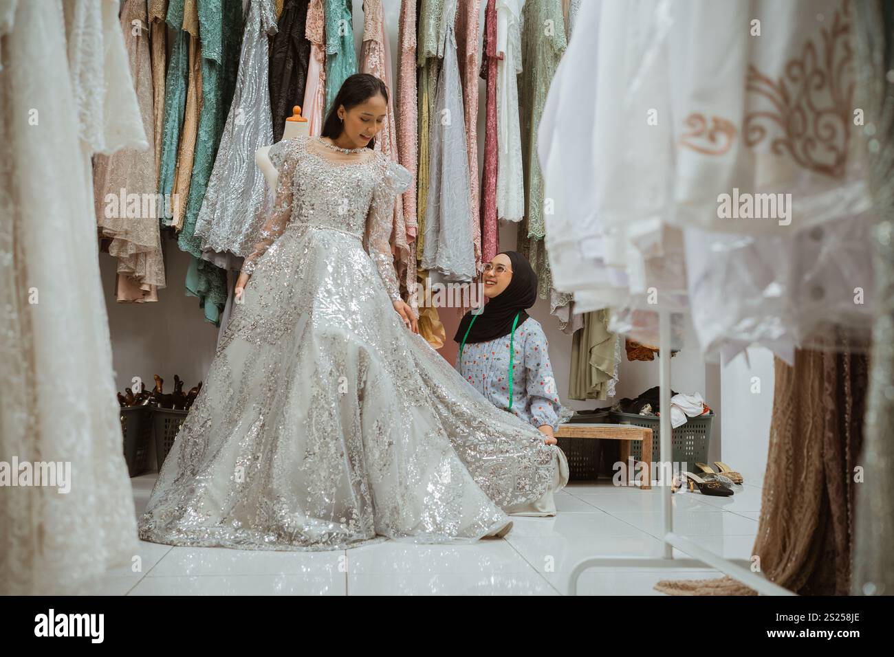 The bride is trying on an absolutely stunning silver gown in a chic ...