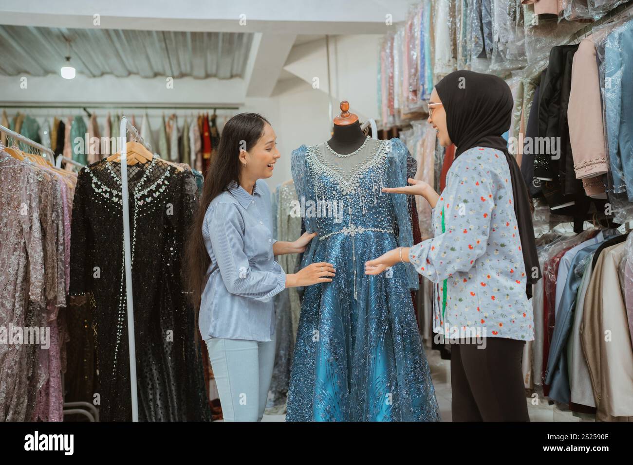 Two women delightfully admiring a sparkling dress displayed in a chic ...