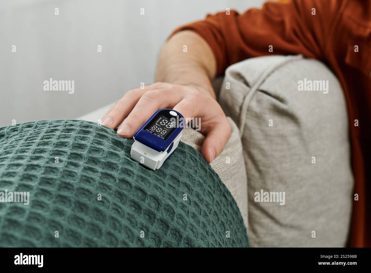 A young man manages his diabetes while relaxing at home, focusing on ...
