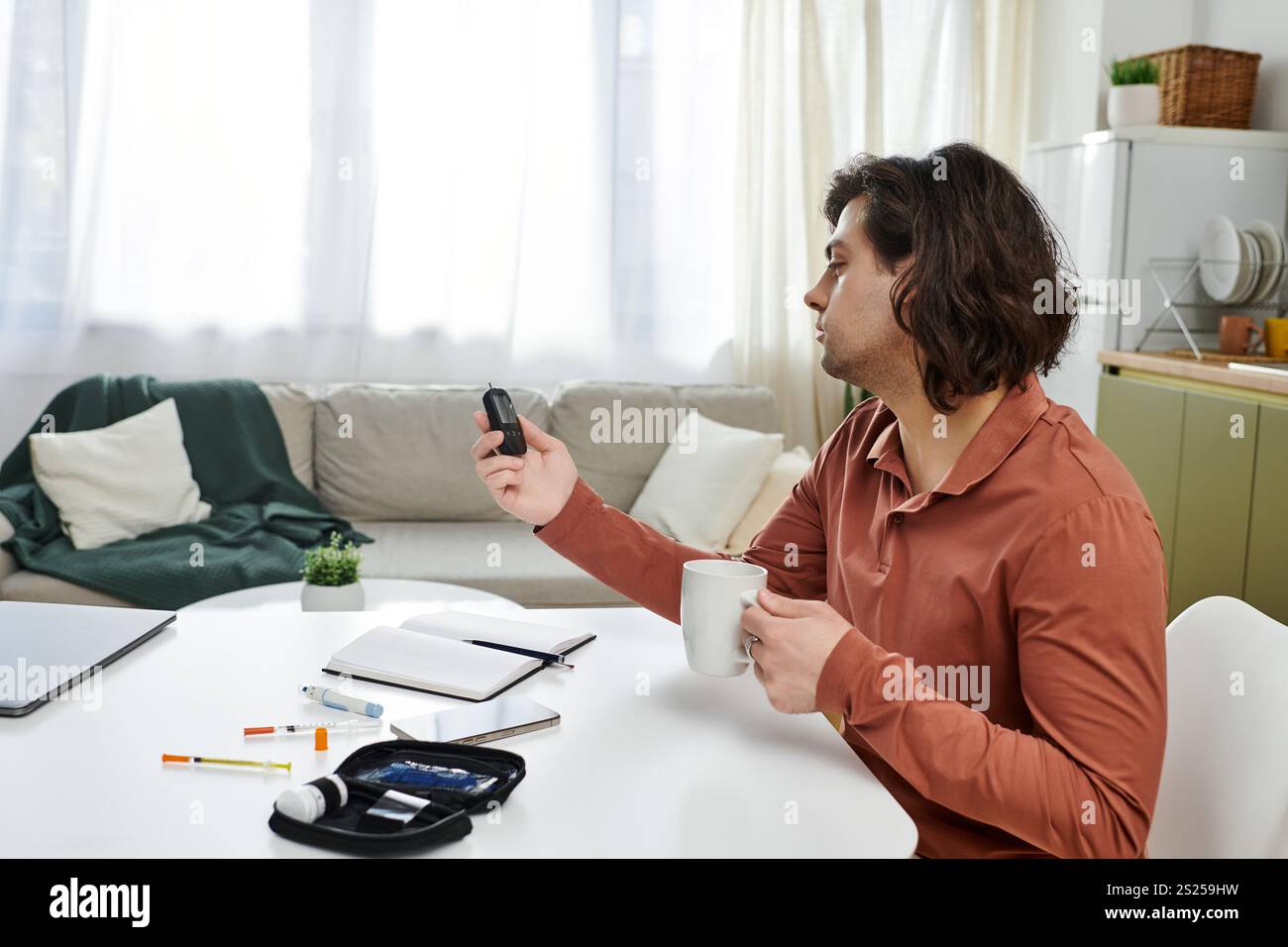 A young man with diabetes demonstrates his daily routine at home ...