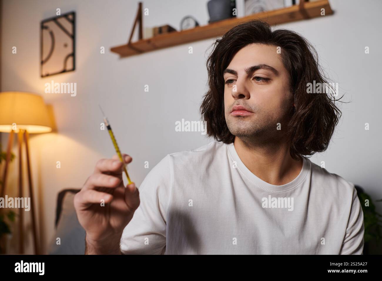 A young man is preparing his insulin in a stylish, well-lit apartment ...