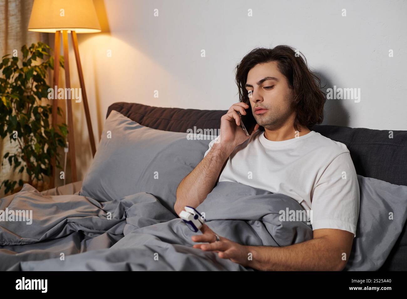 Young man manages his diabetes routine while relaxing at home on a cozy ...