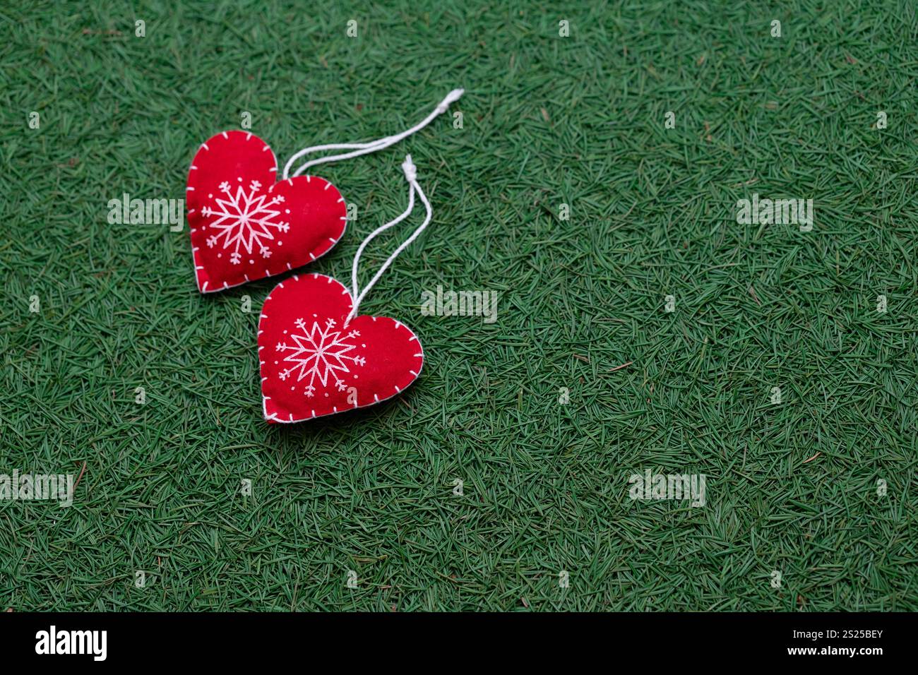 red heart on a pine needless scattering, dark green textured background ...