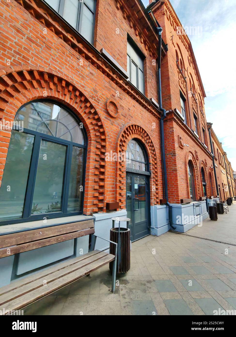Close-up of a historic red brick building facade with arched windows ...