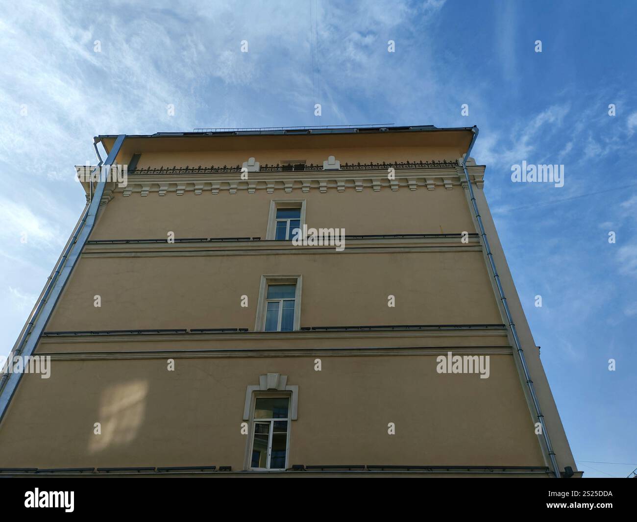 A beige building with minimal ornamentation, featuring evenly spaced ...