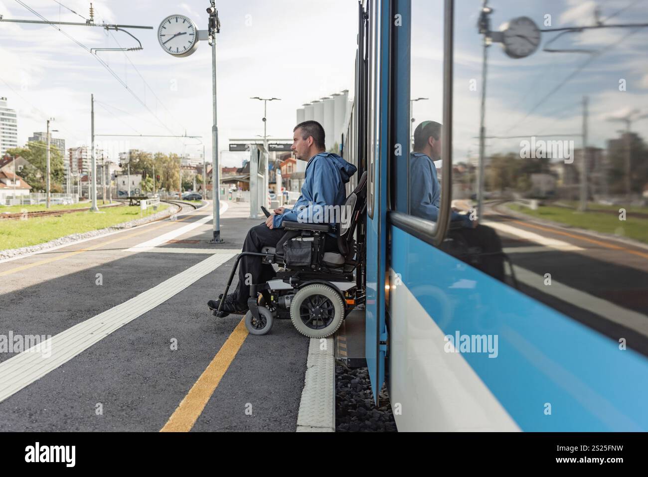 Man with disability on electric wheelchair entering a train. Accessible ...