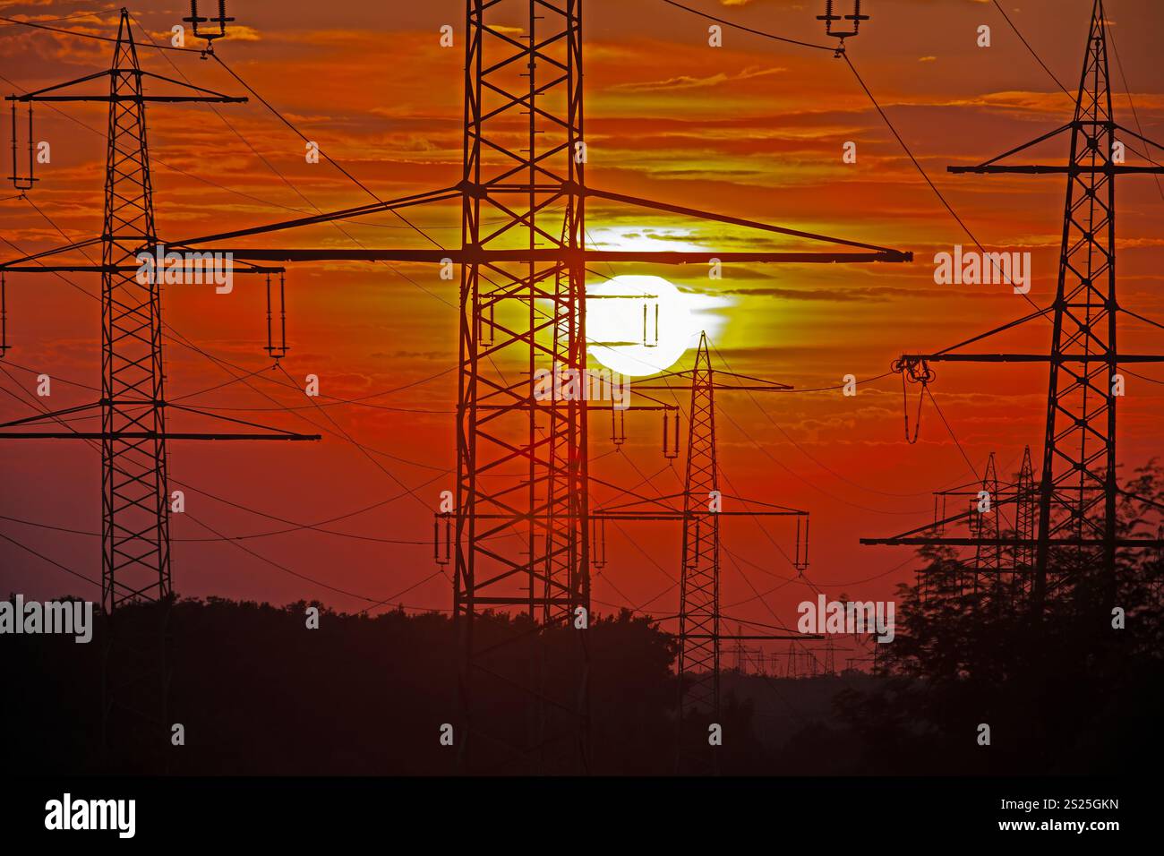 Power transmission towers silhouetted against a sunset sky Stock Photo ...