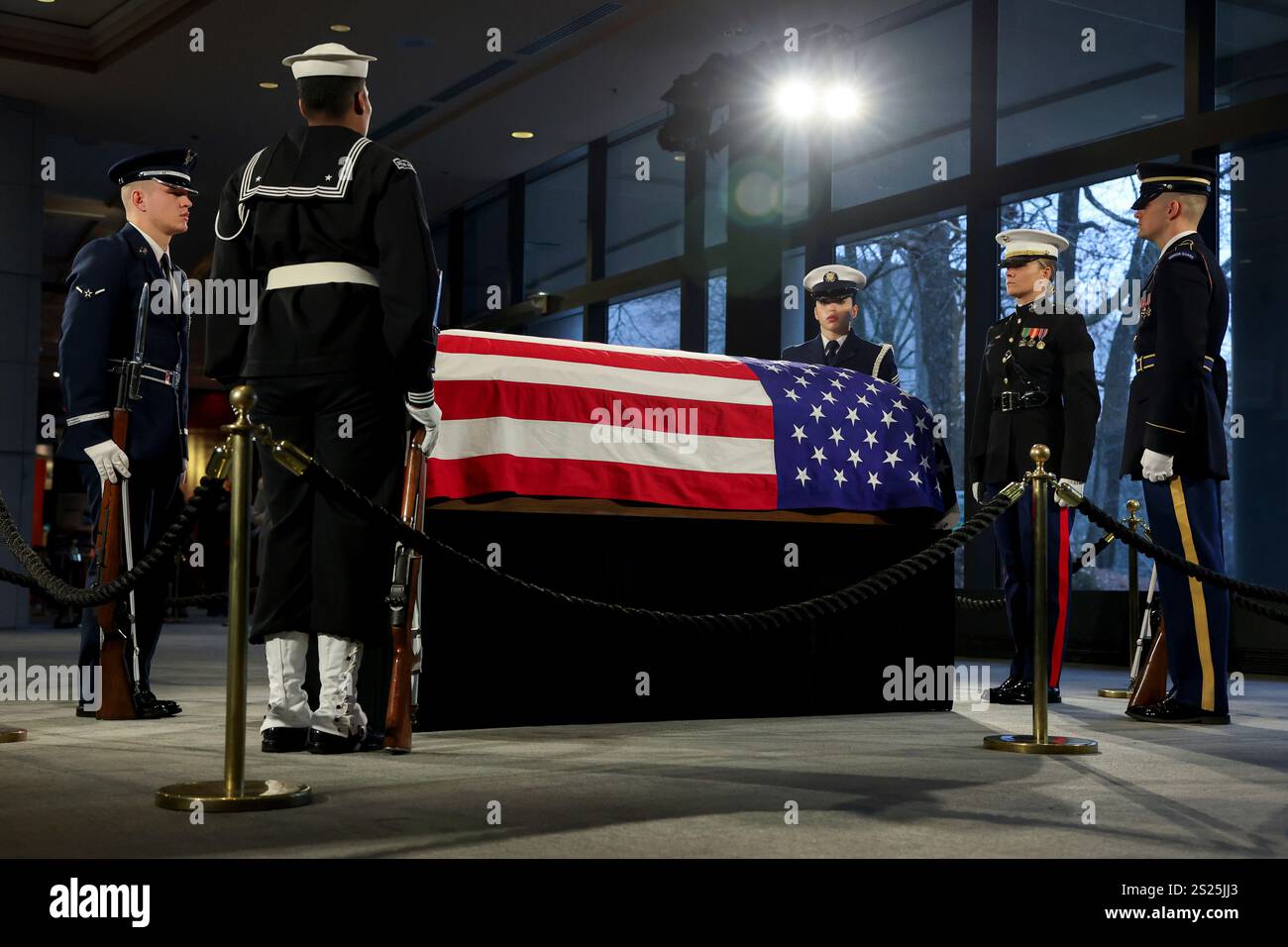 Members of the joint services military honor guard stand next to the casket bearing the remains ...