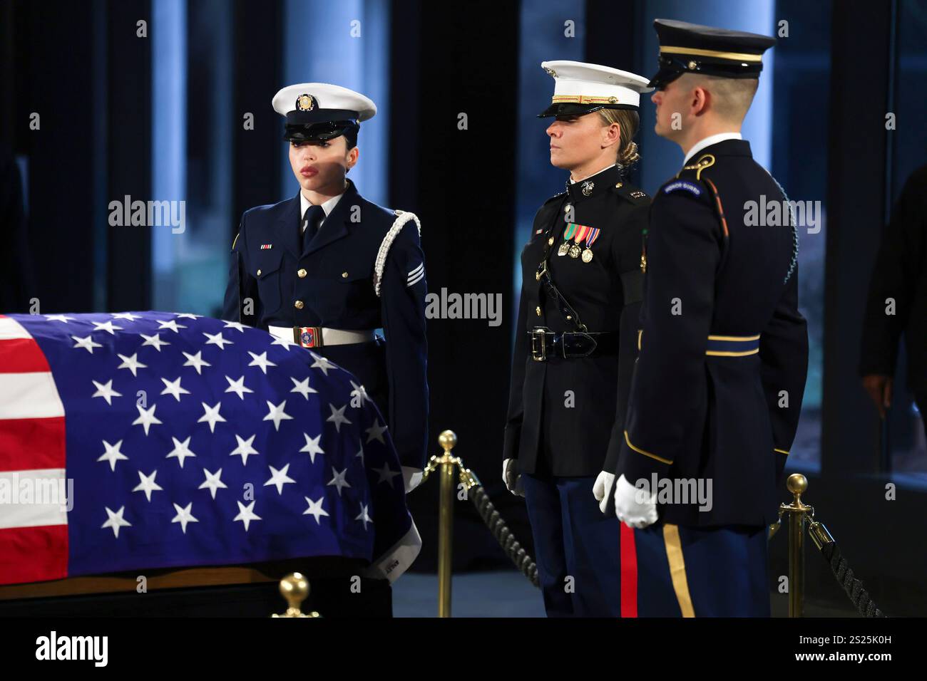 Members of the joint services military honor guard stand next to the casket bearing the remains ...